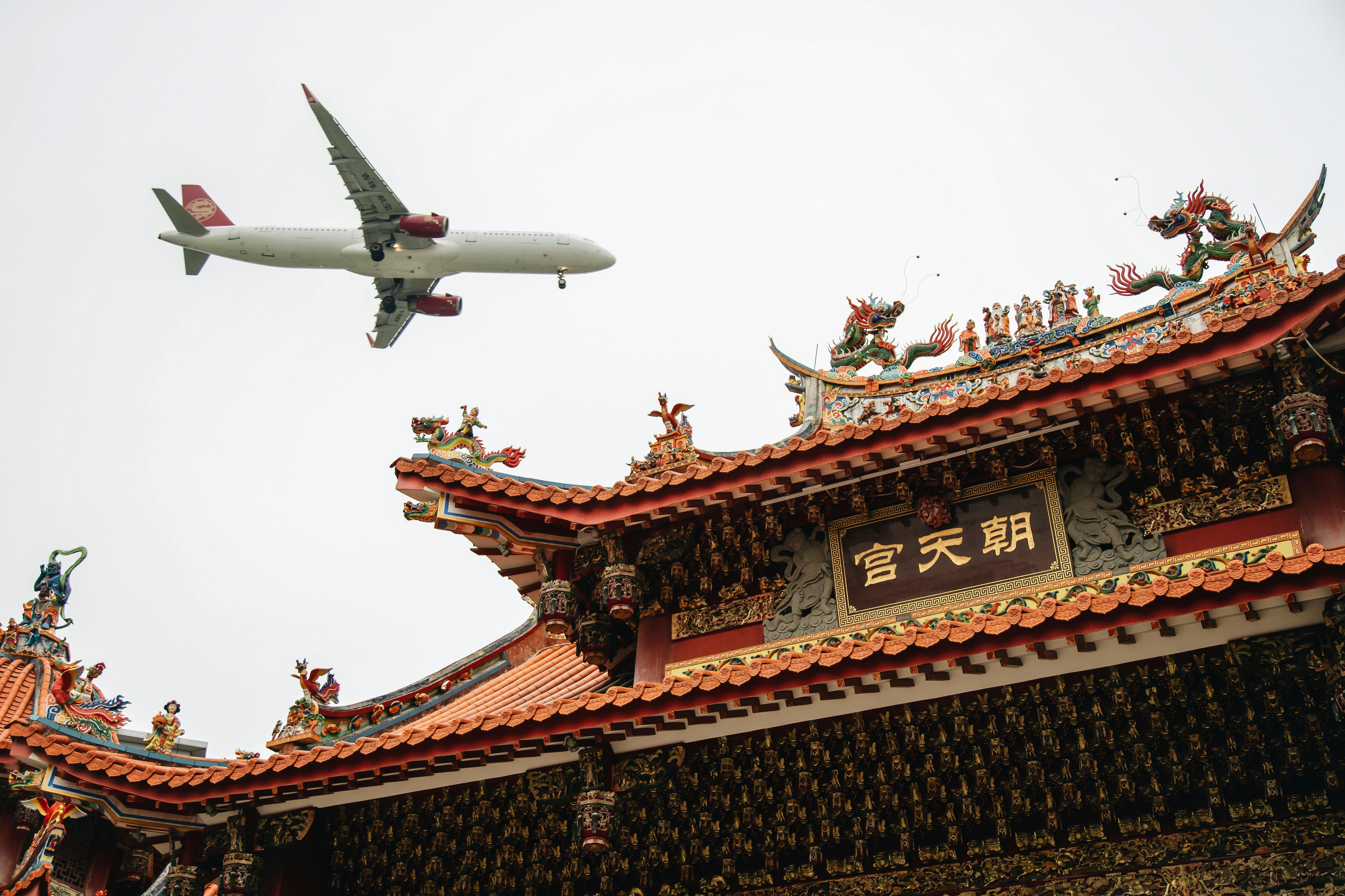 Passenger Airplane Flying over a Traditional Chinese Building · Free ...