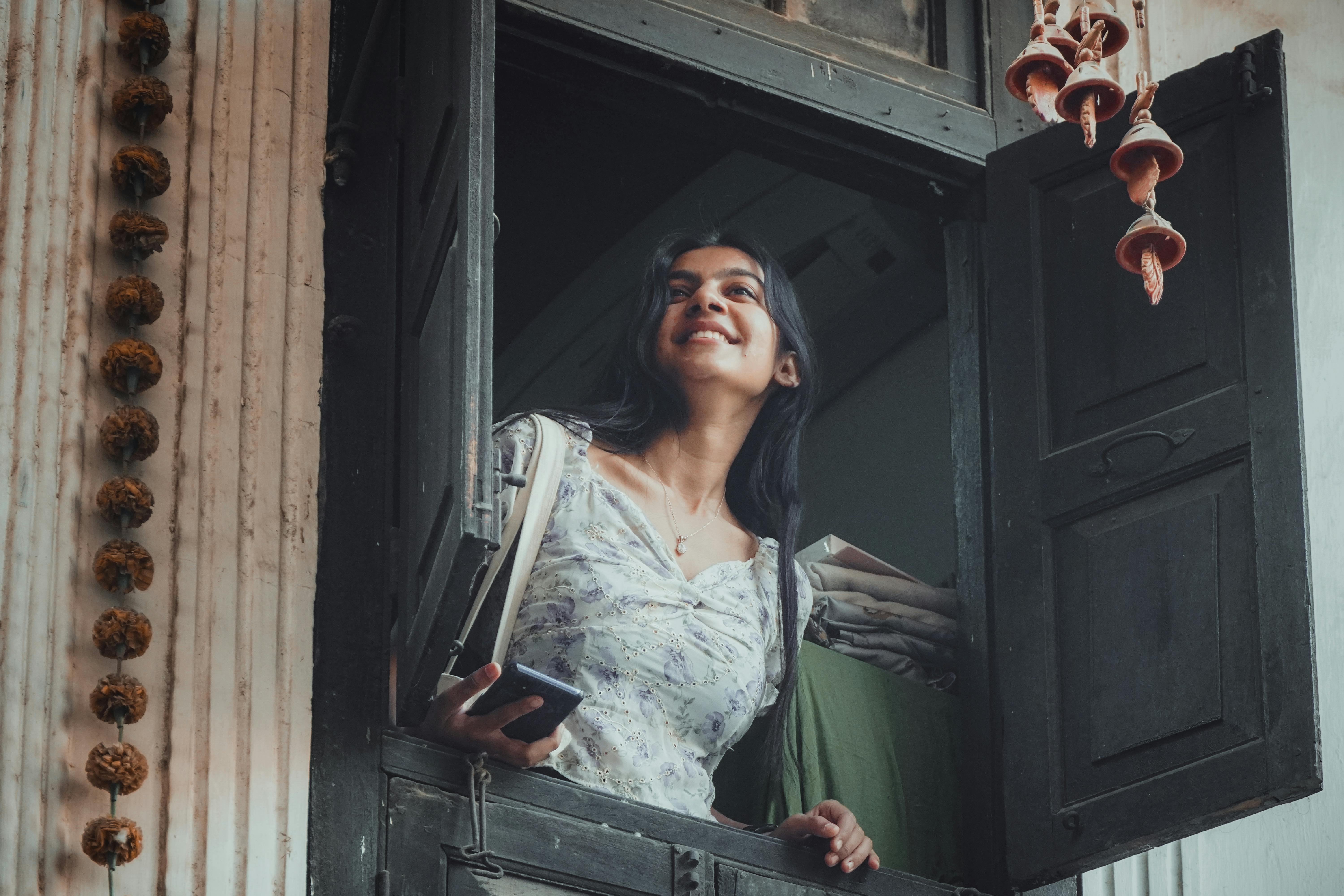 Smiling Woman Standing in Window · Free Stock Photo