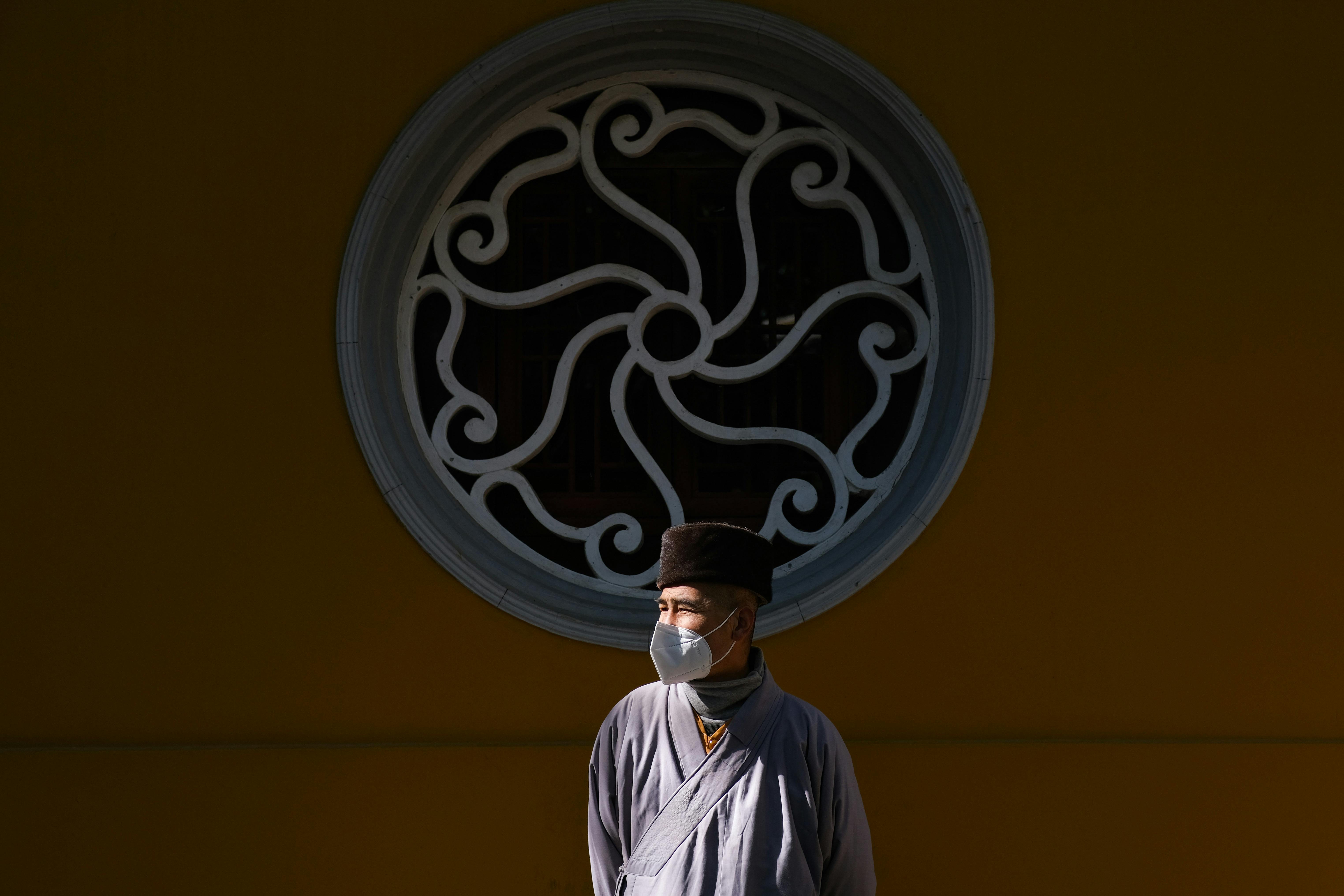 Man in Mask Standing near Wall with Ornamented Window · Free Stock Photo