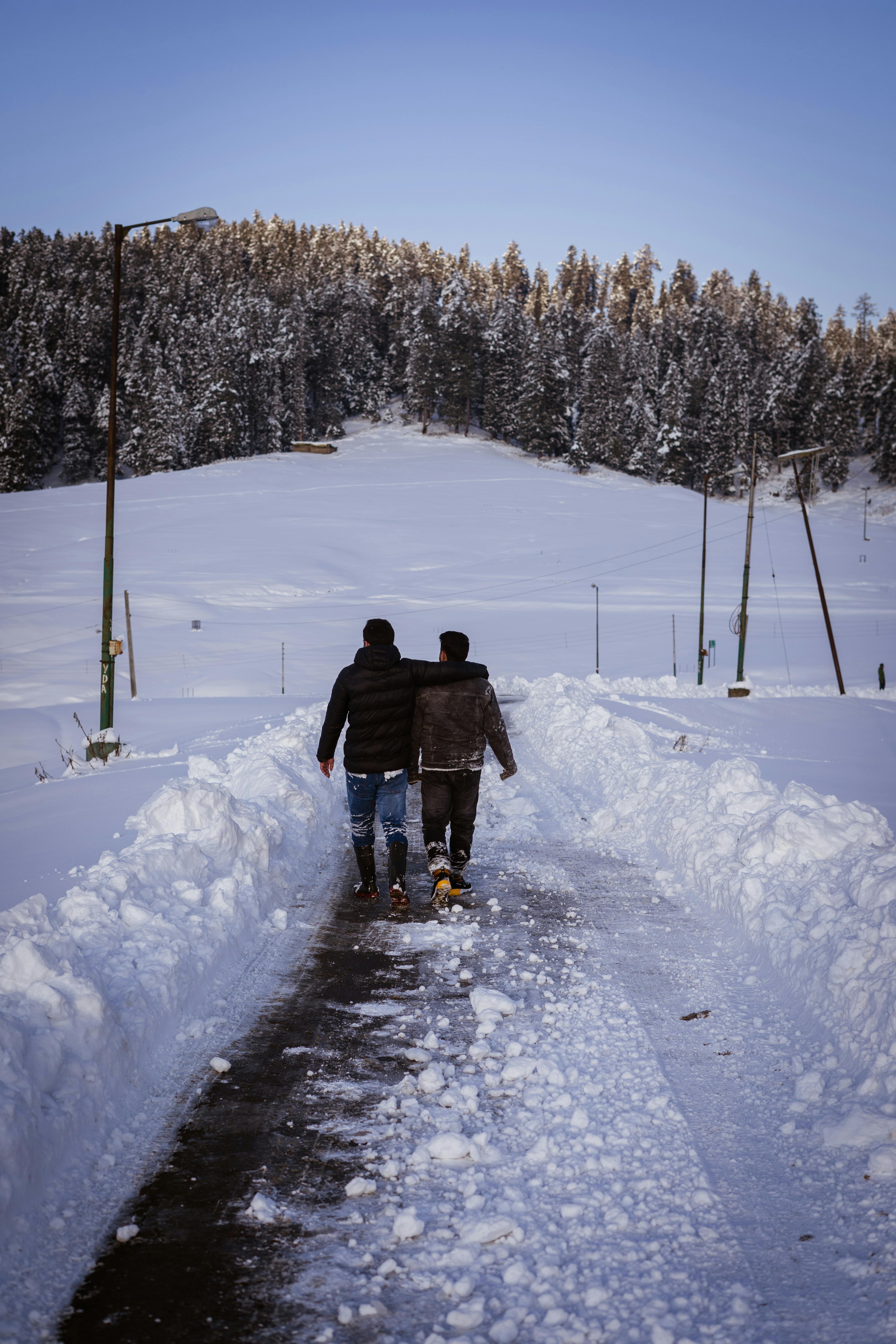 Photo of Person Walking on Snow Covered Ground · Free Stock Photo