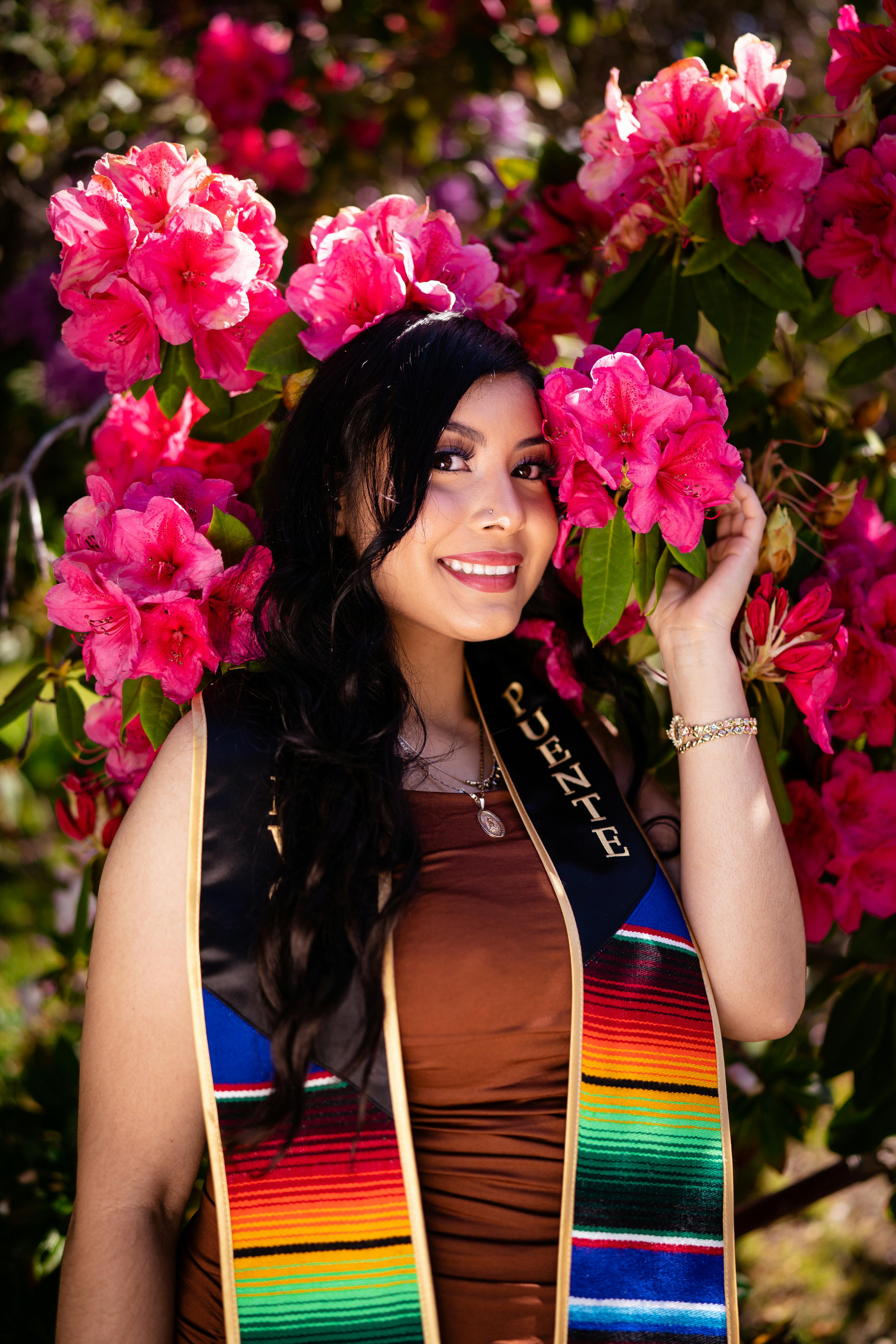 Smiling Woman with Graduation Stole Posing in Garden · Free Stock Photo
