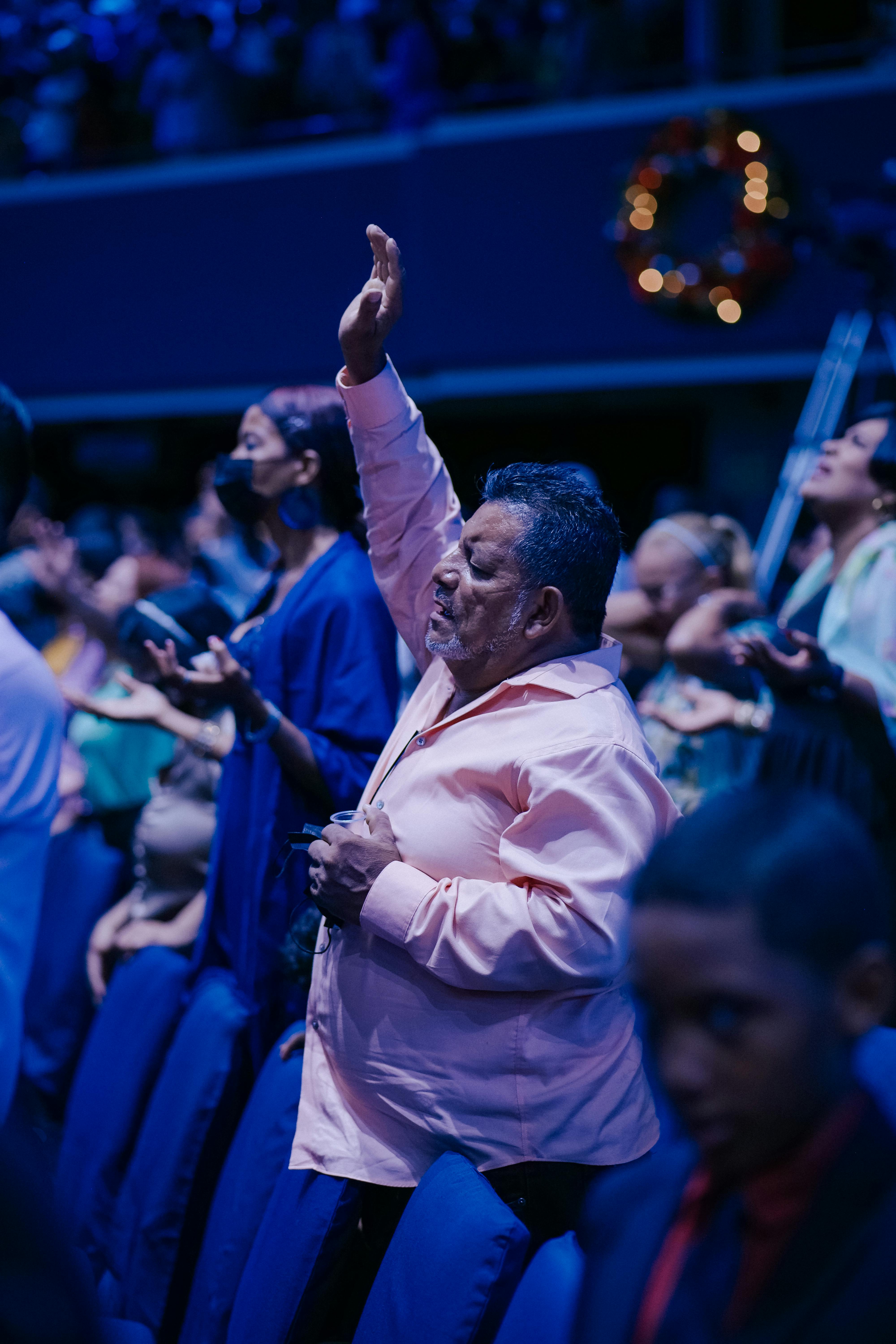 Photo of a Man Raising his Hands towards a Stage with a Cross · Free ...