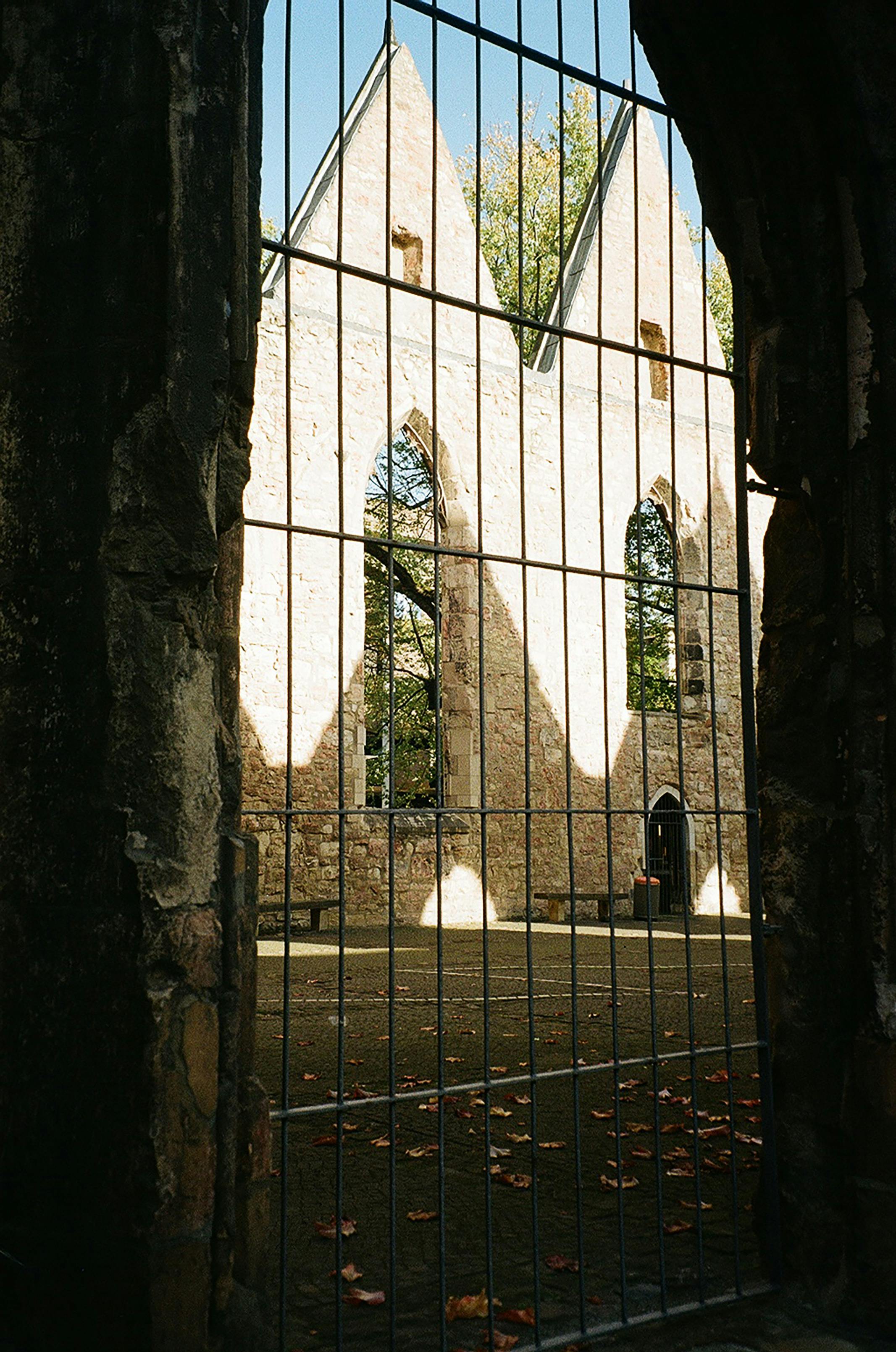 A Brick Wall with Window Opening Behind Metal Grills · Free Stock Photo