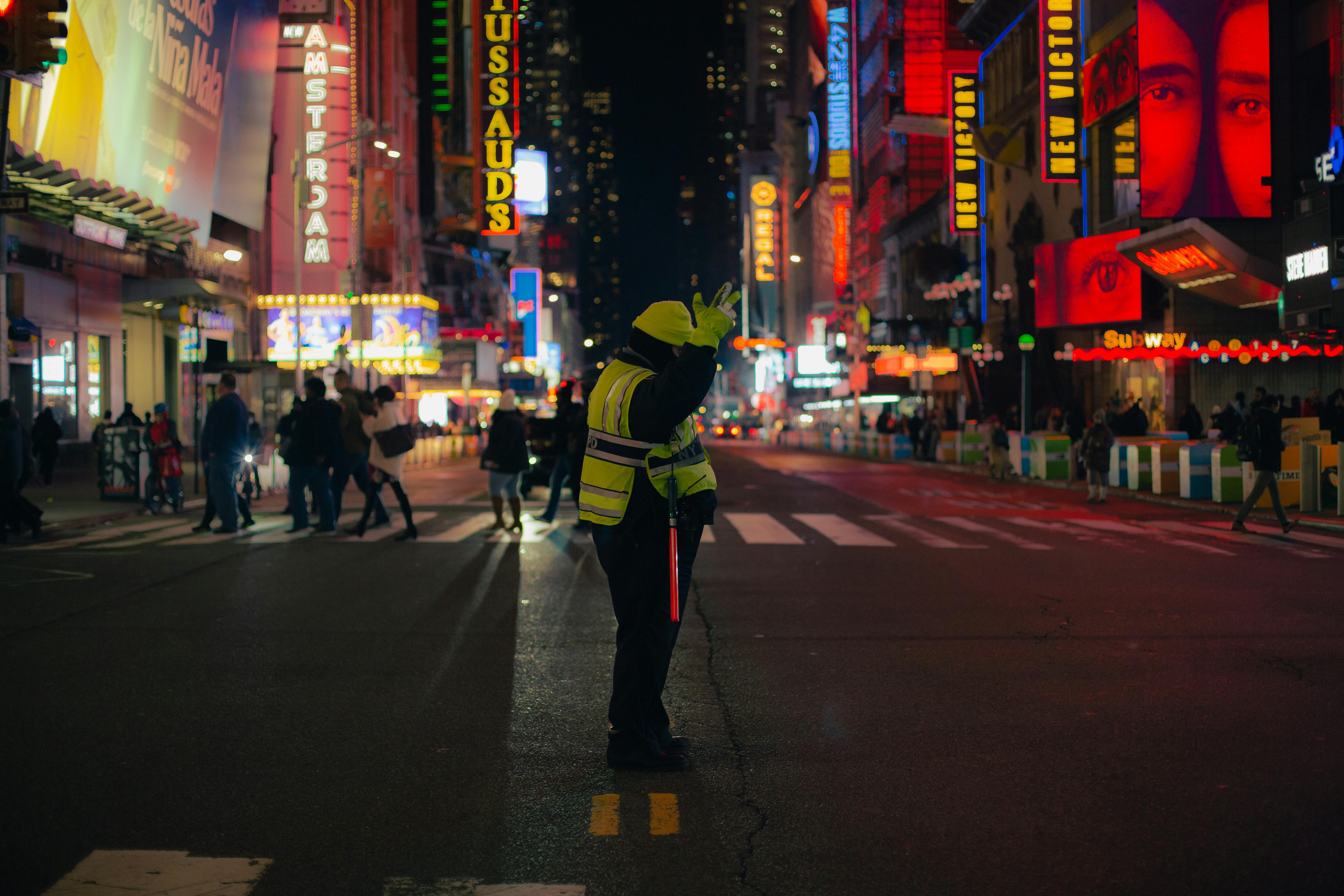 Police Officer in Reflective Vest Standing on Street in City at Night ...