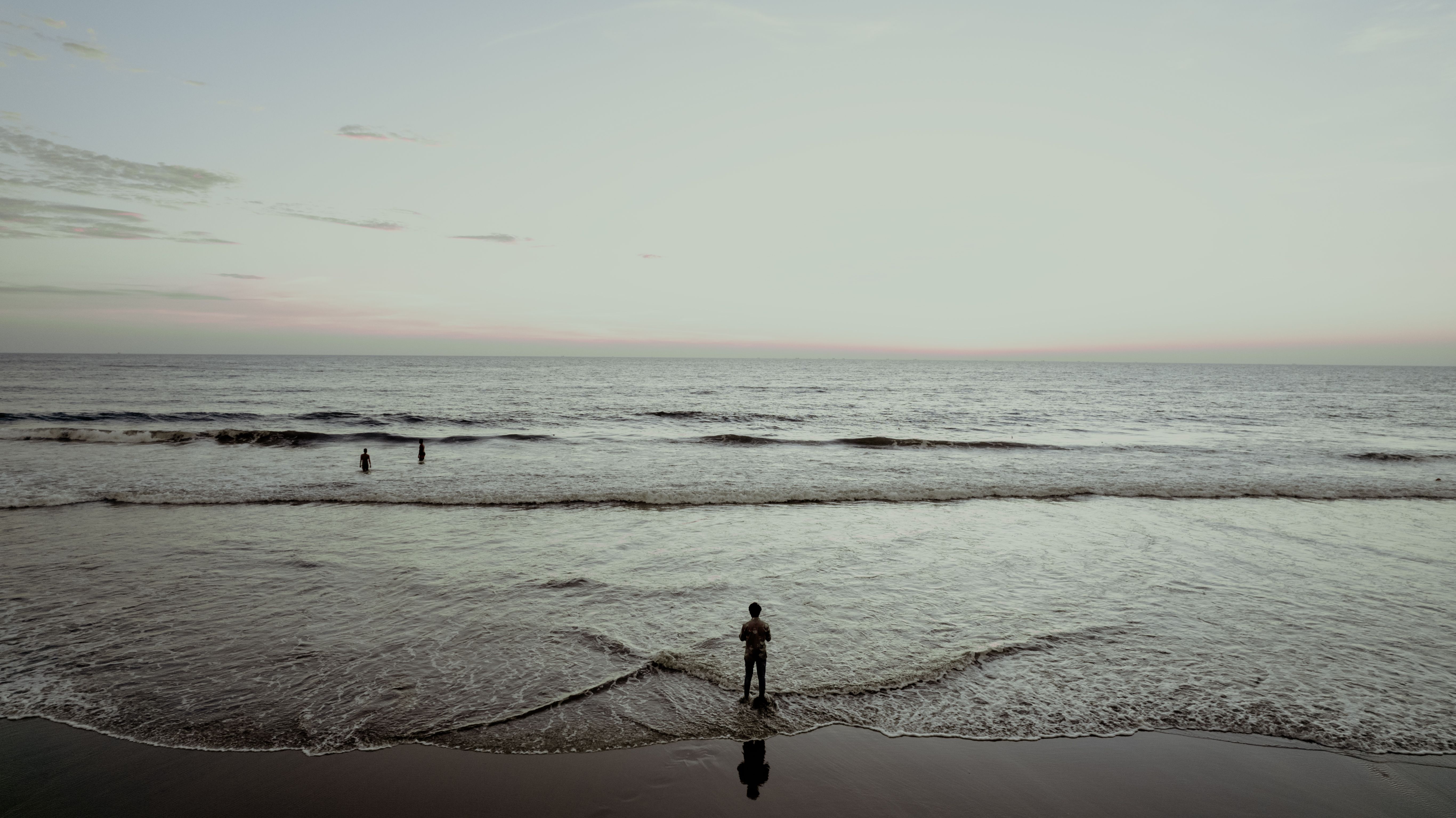 Person Standing on Beach Shore · Free Stock Photo