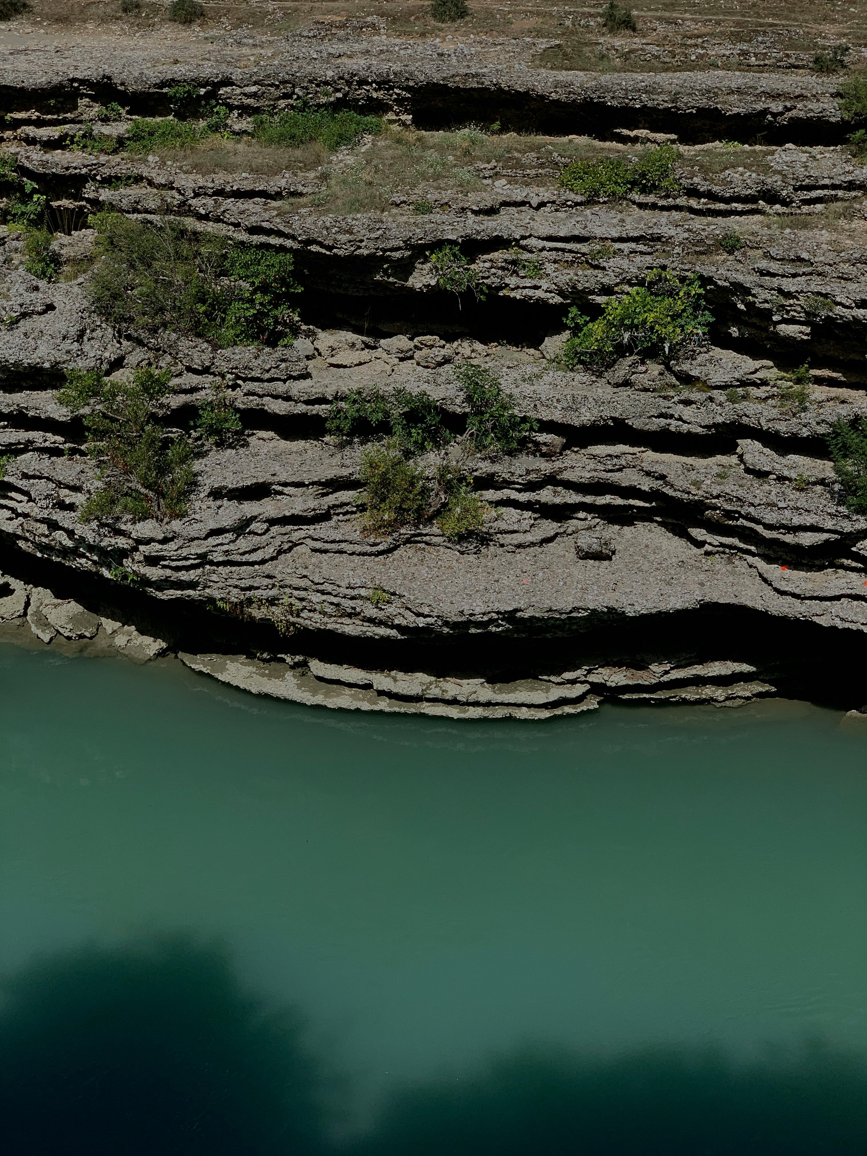 Uneven Rock Formation near Body of Water · Free Stock Photo