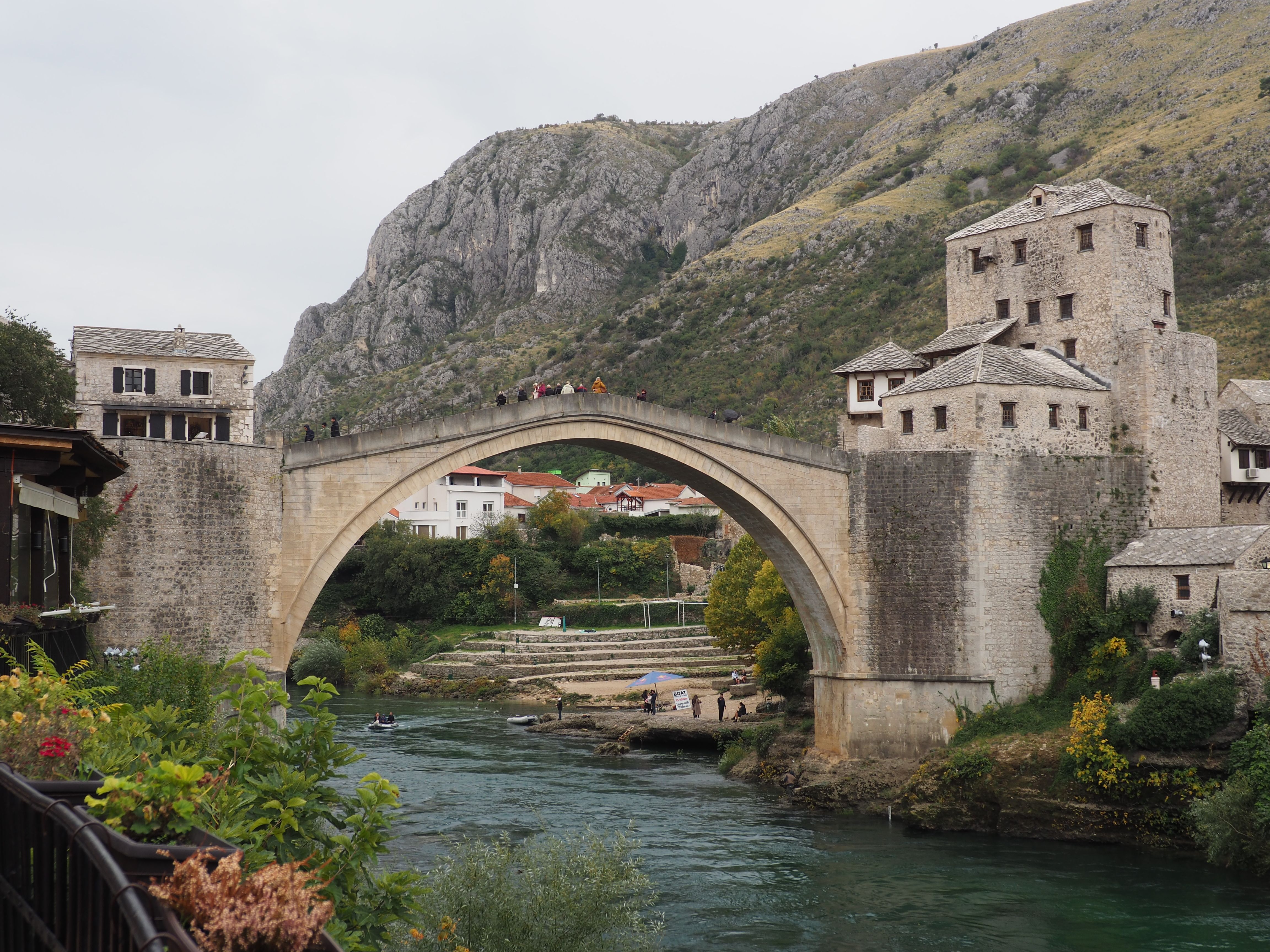 Bridge on River in Town near Hill · Free Stock Photo