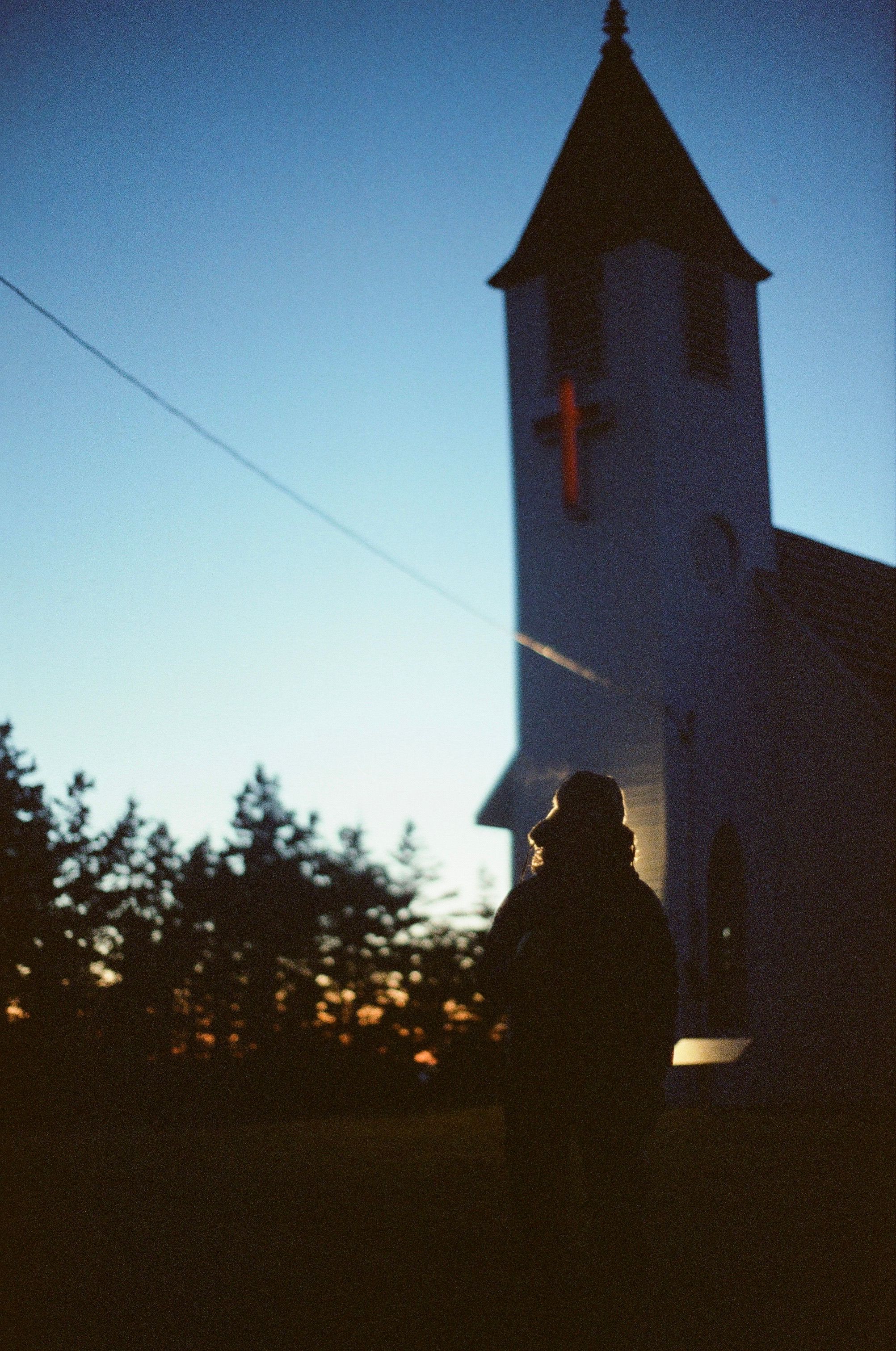 Silhouette of Person Standing in Front of Church · Free Stock Photo