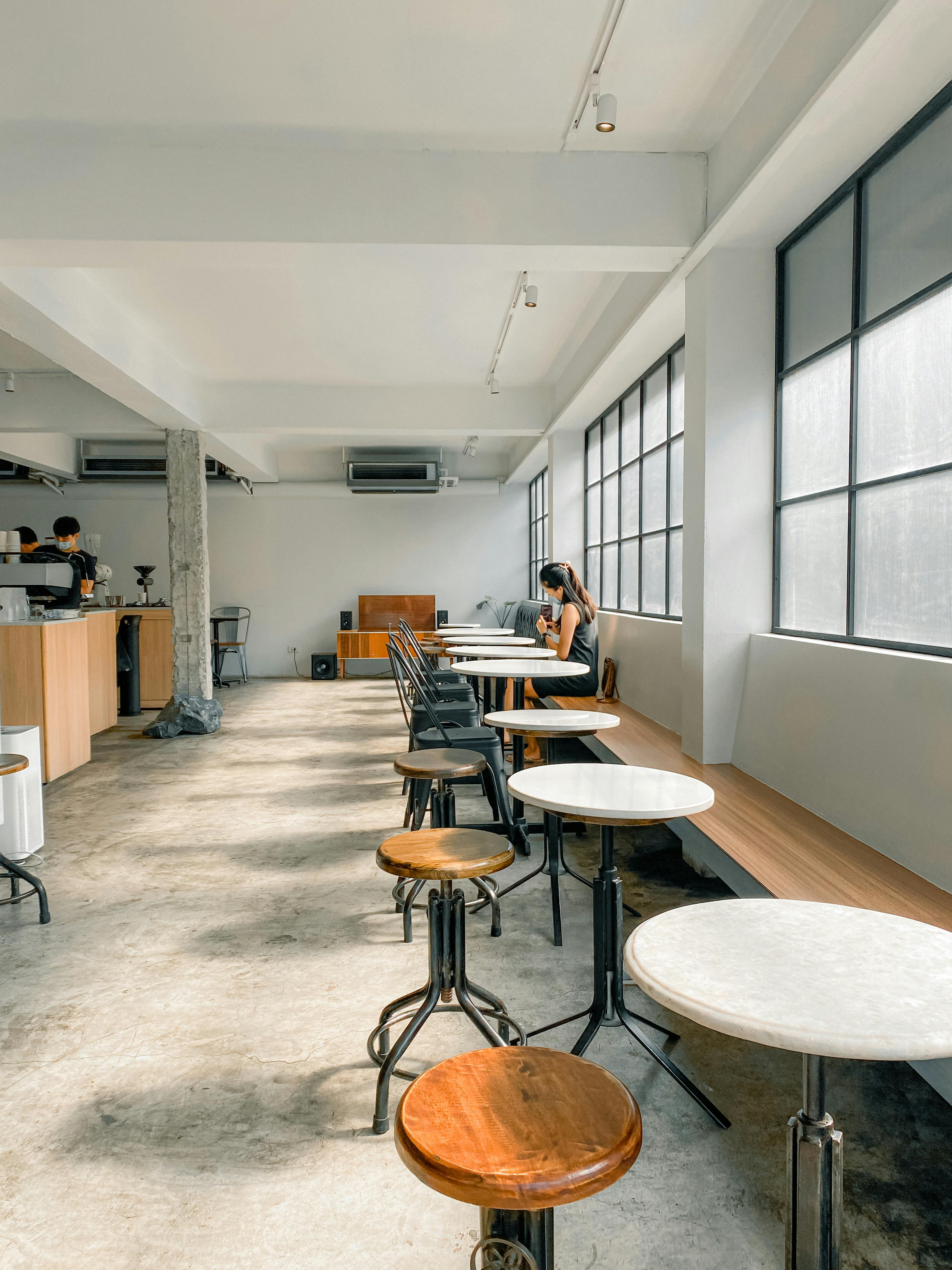 Woman Sitting by Round Table in Cafe · Free Stock Photo