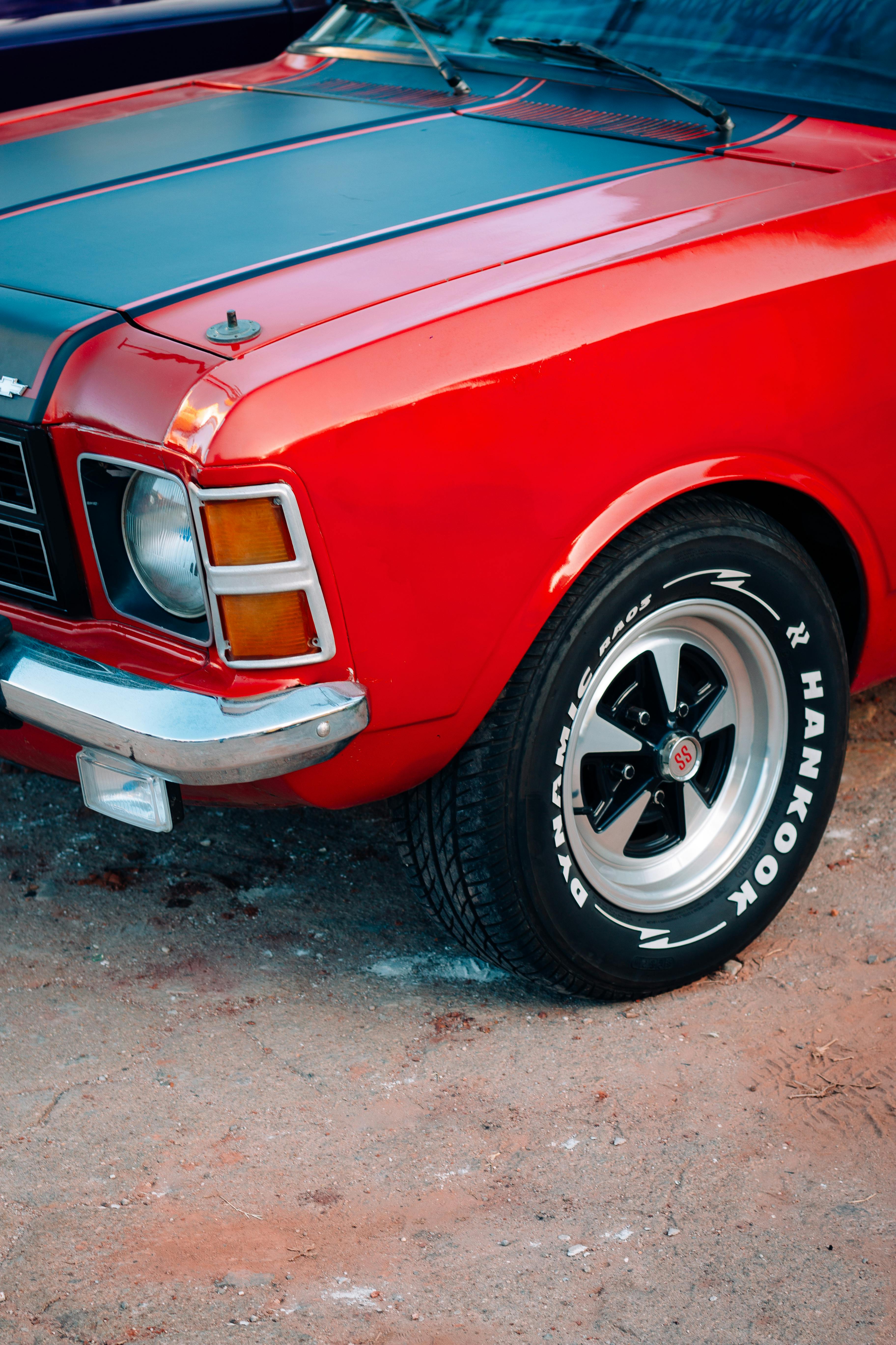 Classic Red Car Parked Near Green Leaf Tree · Free Stock Photo