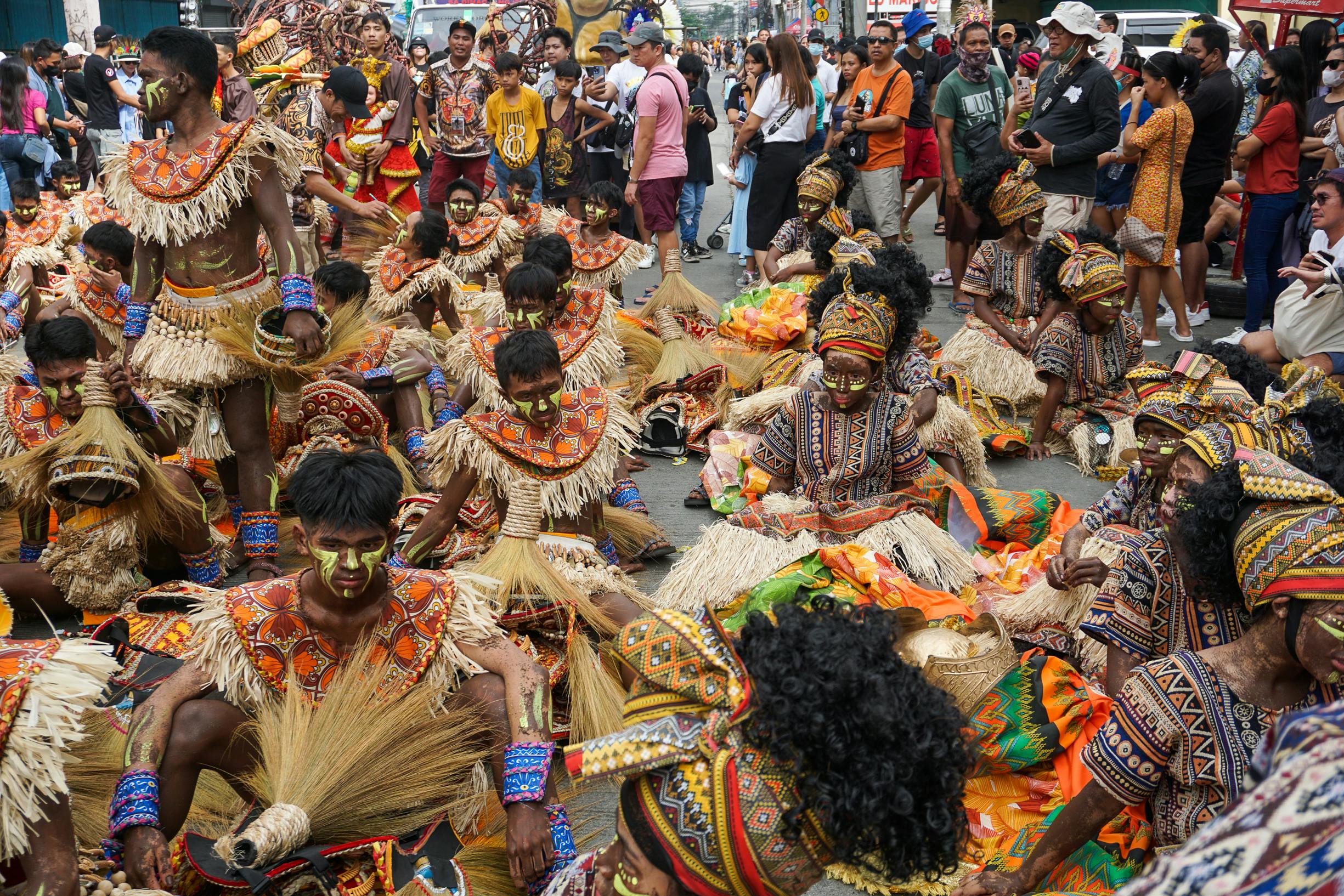 People in Traditional Dress Sitting on Sidewalk · Free Stock Photo