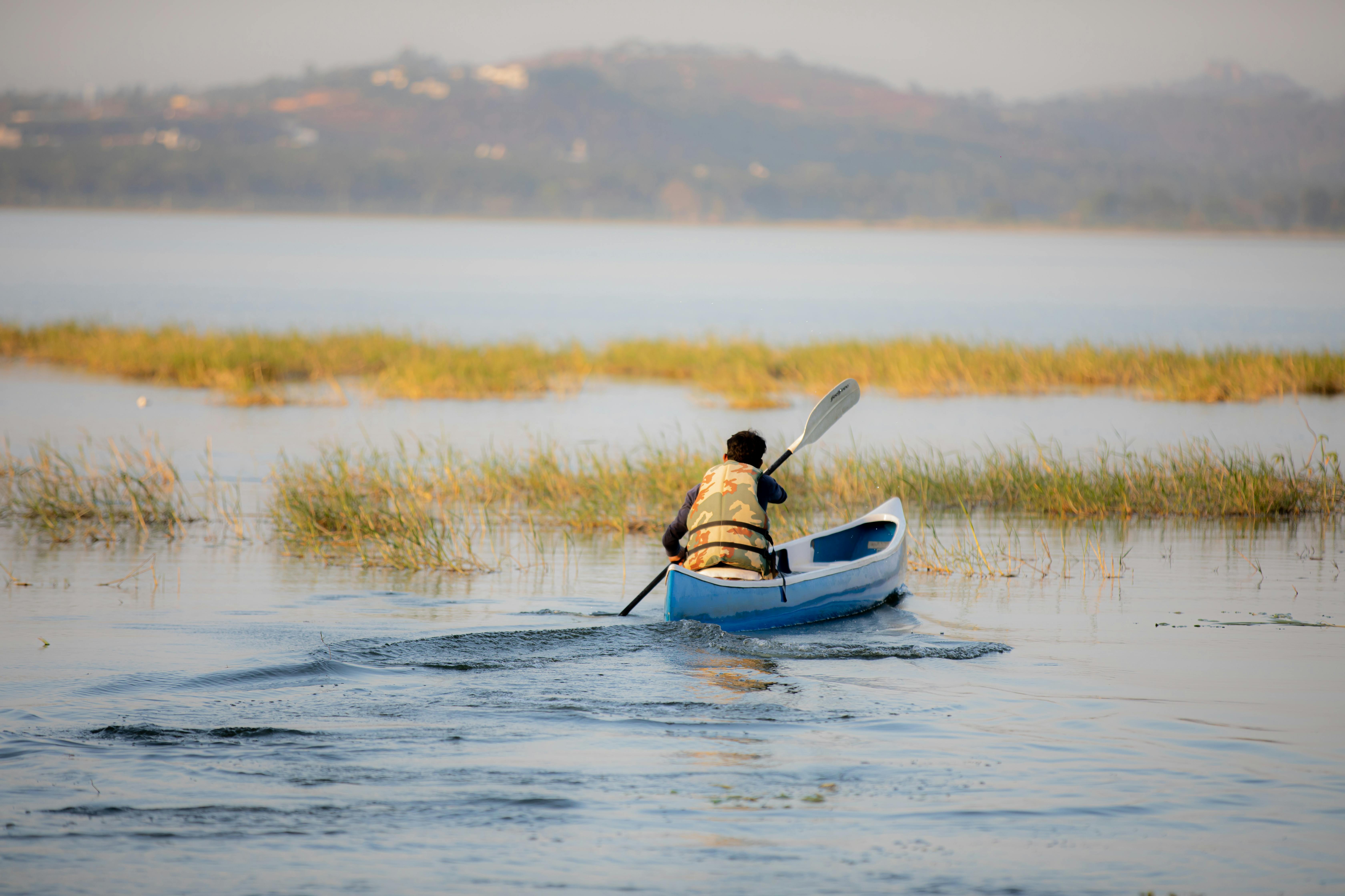 Man Riding on Boat Holding Brown Paddle · Free Stock Photo