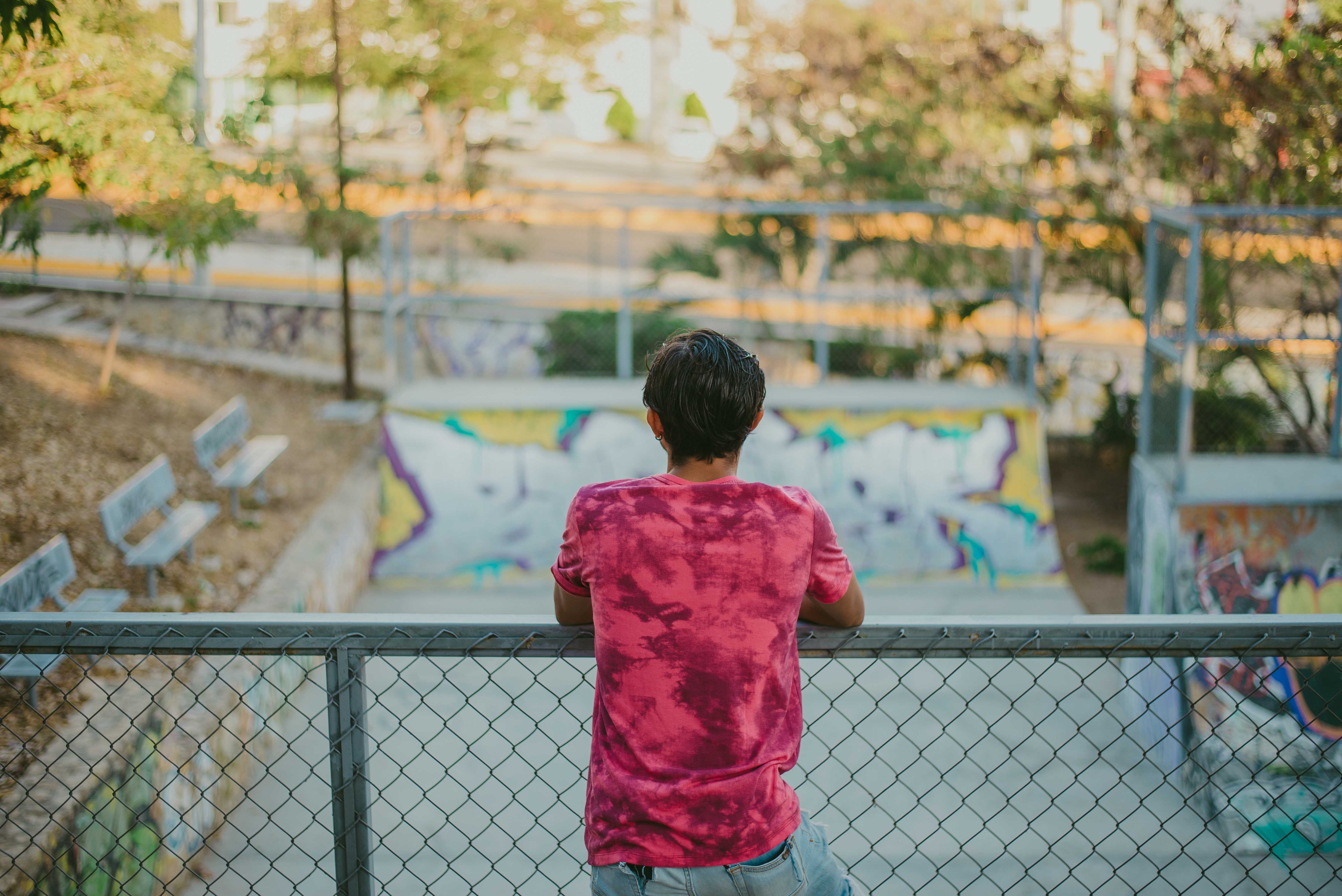Back View of a Man Leaning on the Metal Railings · Free Stock Photo
