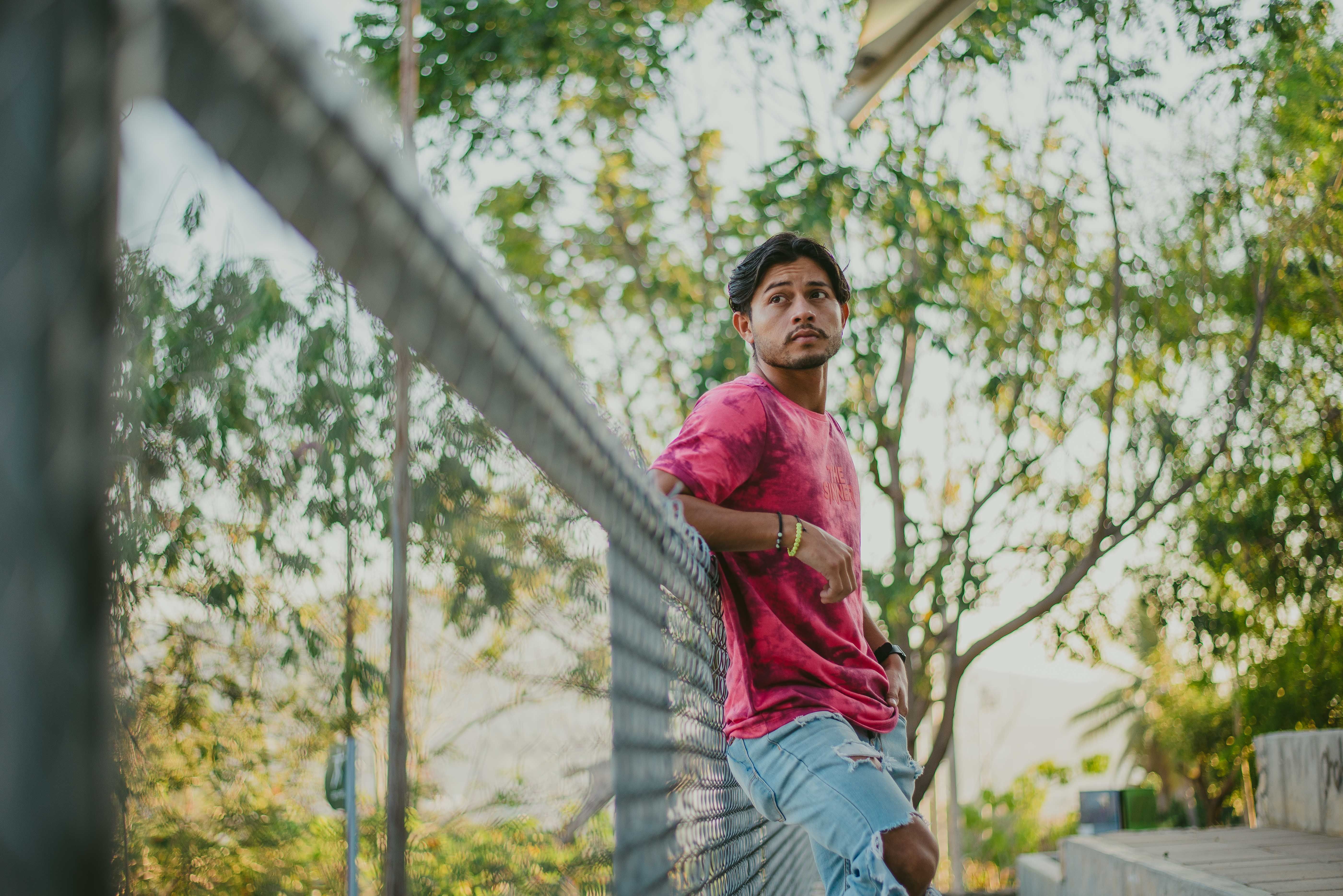 Man Standing and Posing by Fence · Free Stock Photo