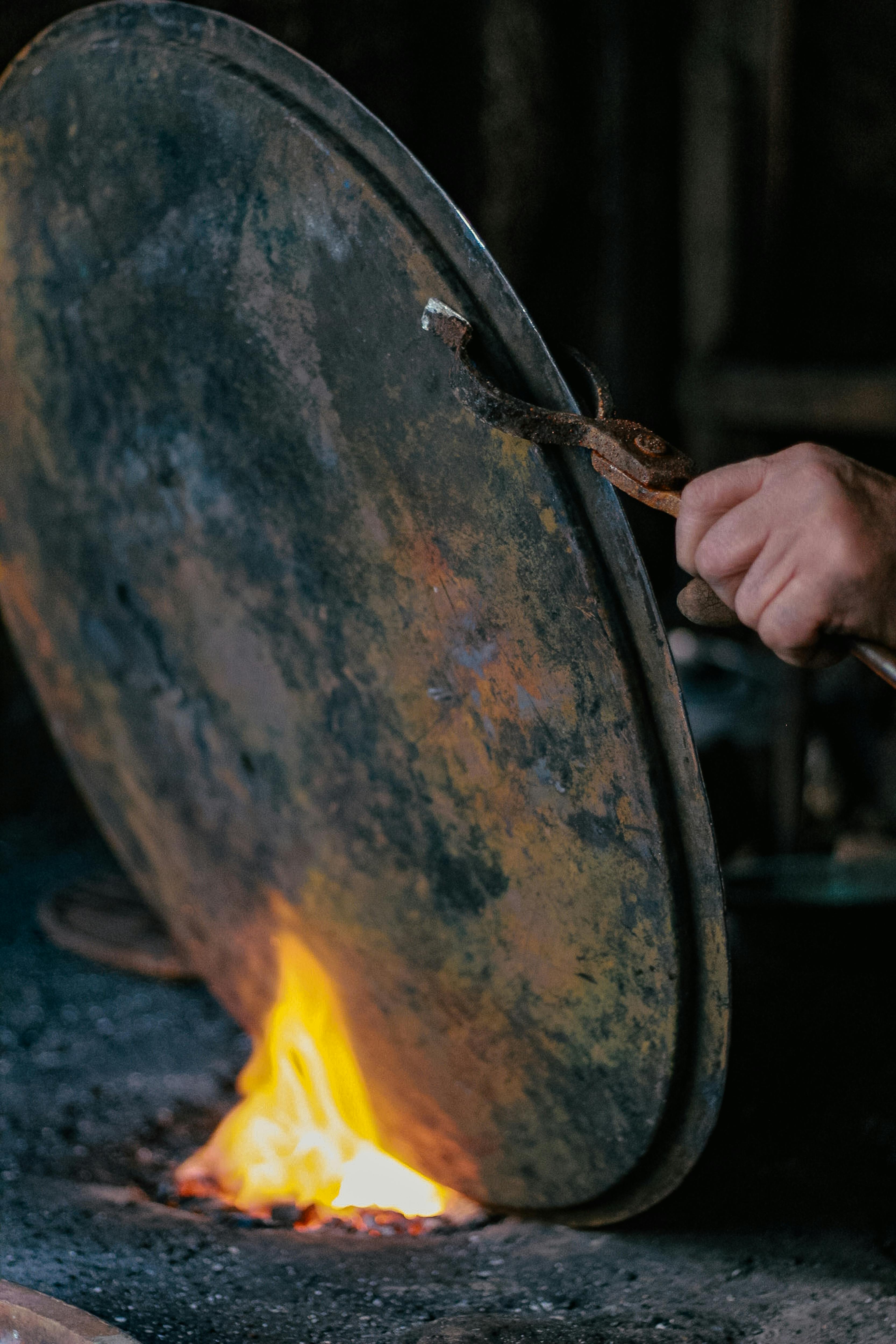 Hand Holding Metal Plate over Fire with Pincers · Free Stock Photo