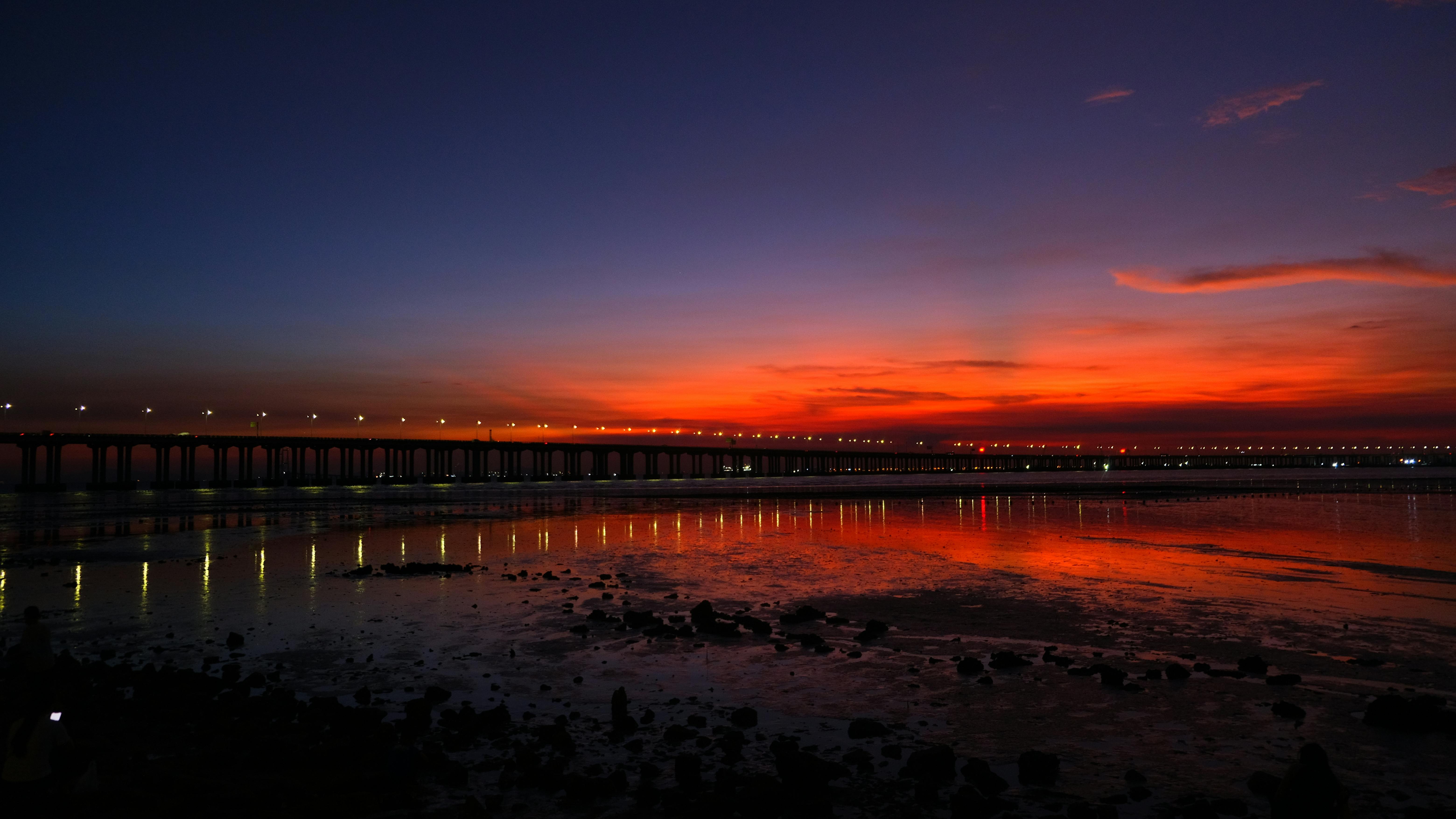 Red Sky at Sunset over Sea Shore near Bridge · Free Stock Photo