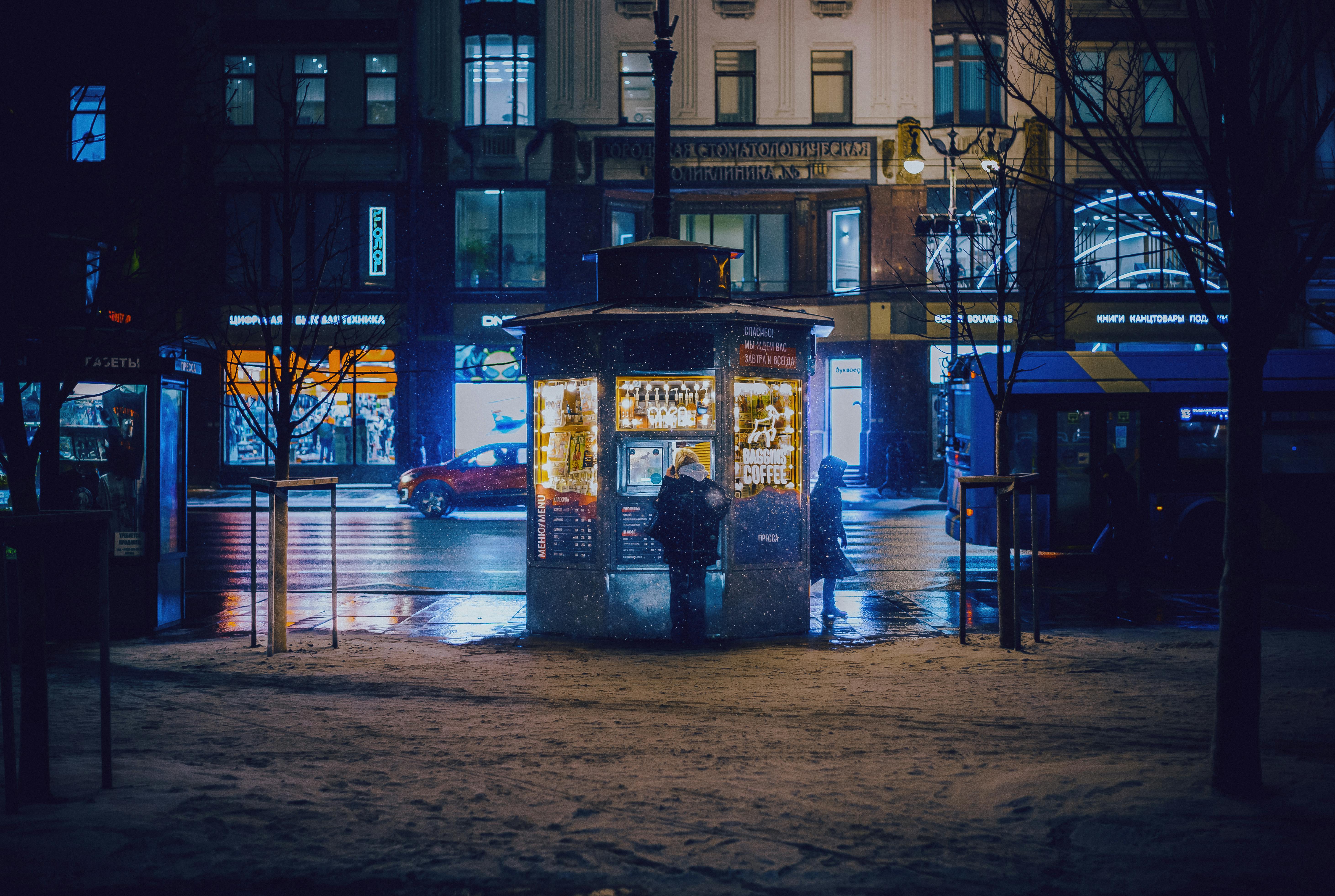 Person Standing Near Kiosk in Winter · Free Stock Photo