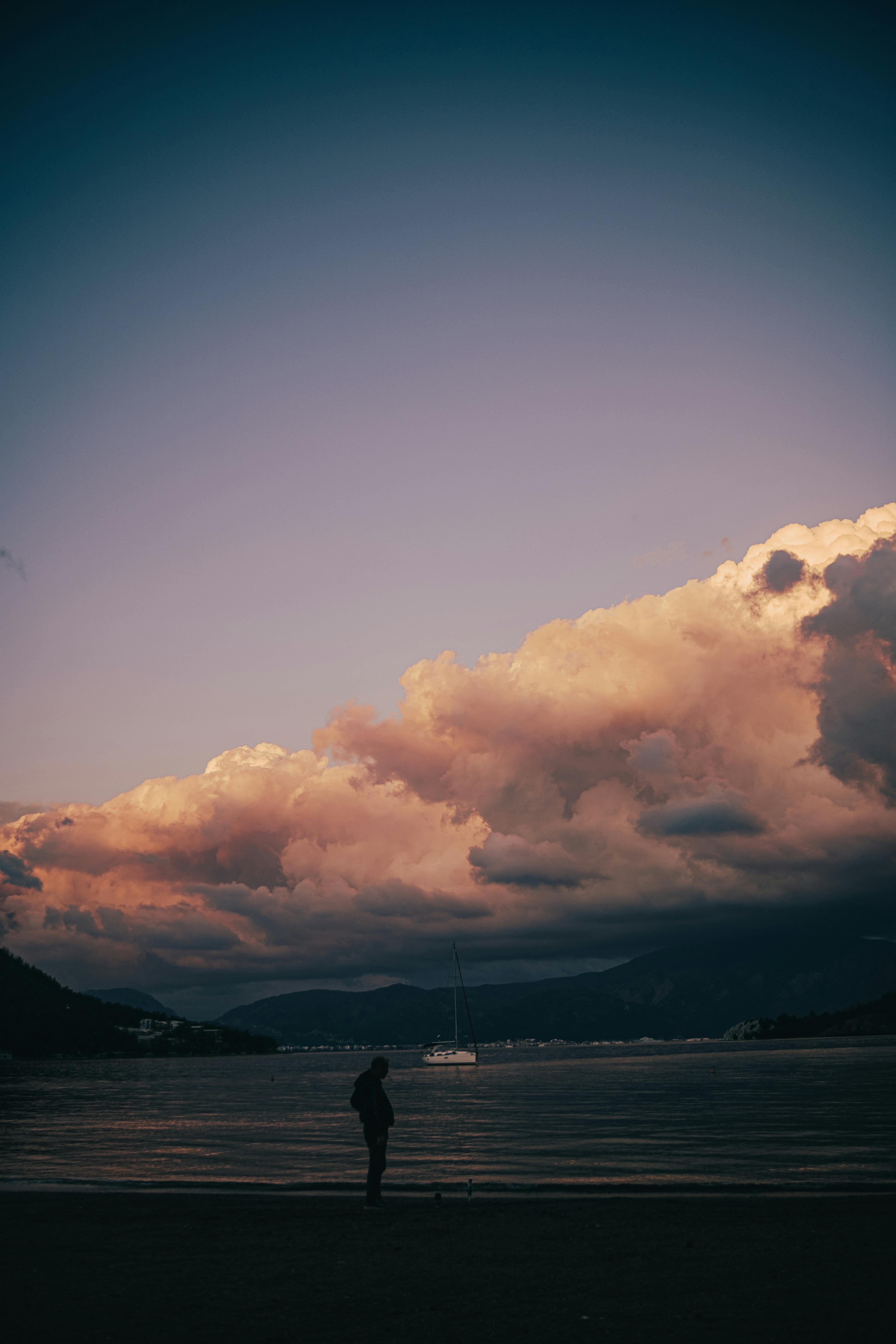 Man Walking on Beach under Clouds · Free Stock Photo