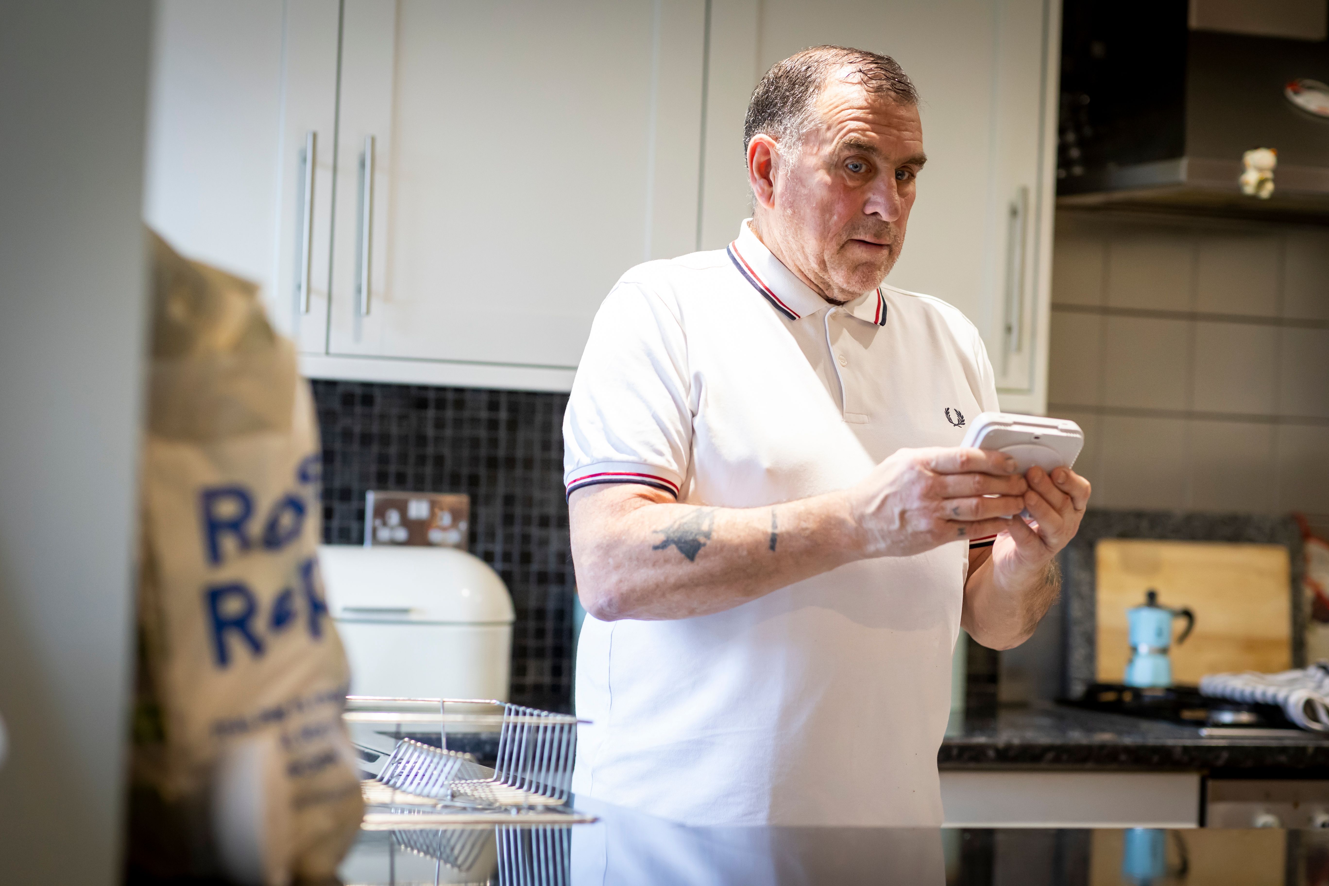 Elderly Man Standing in Kitchen with White Box in Hands · Free Stock Photo