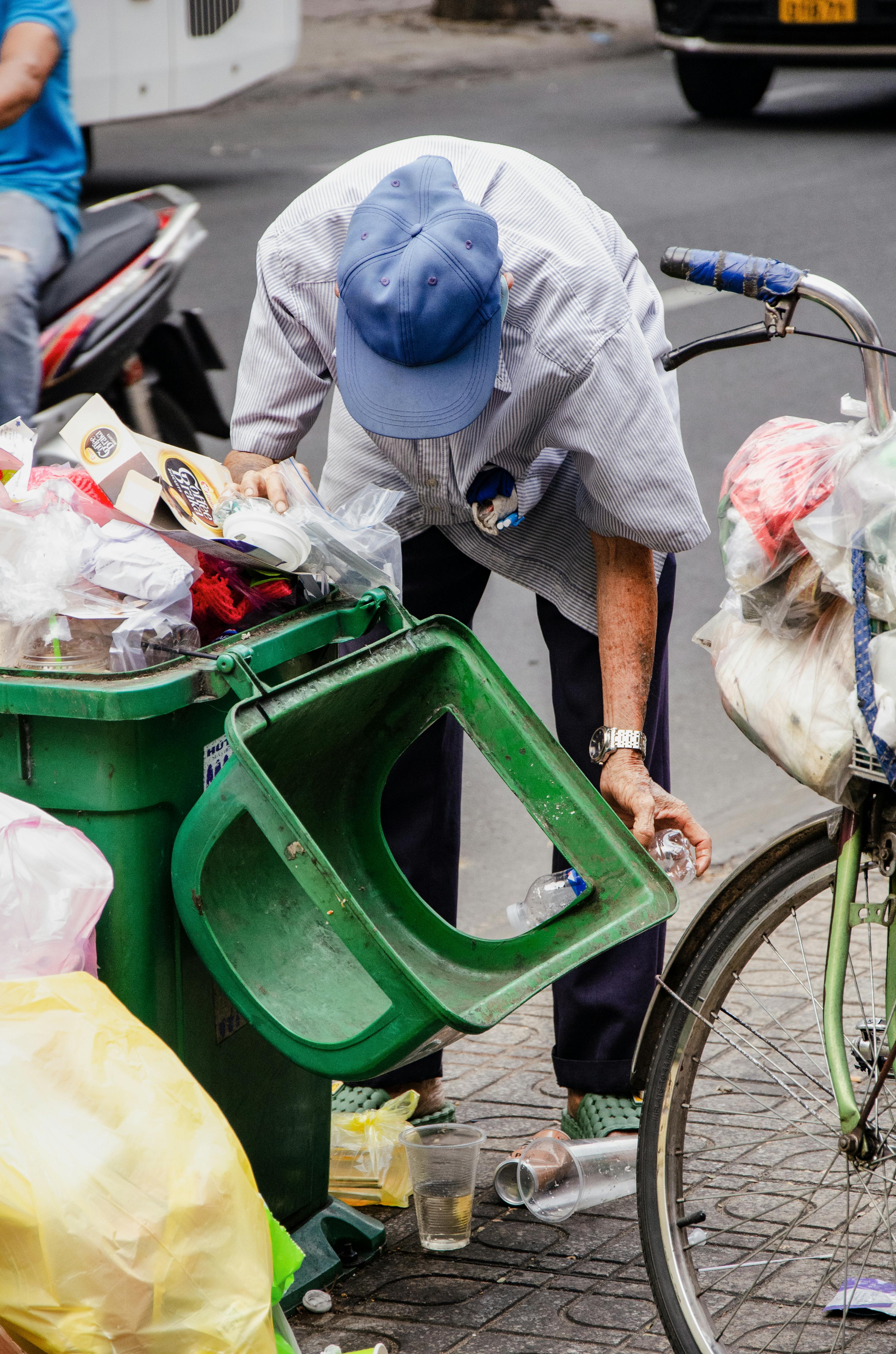 Man with Bicycle Standing near Trash Can · Free Stock Photo