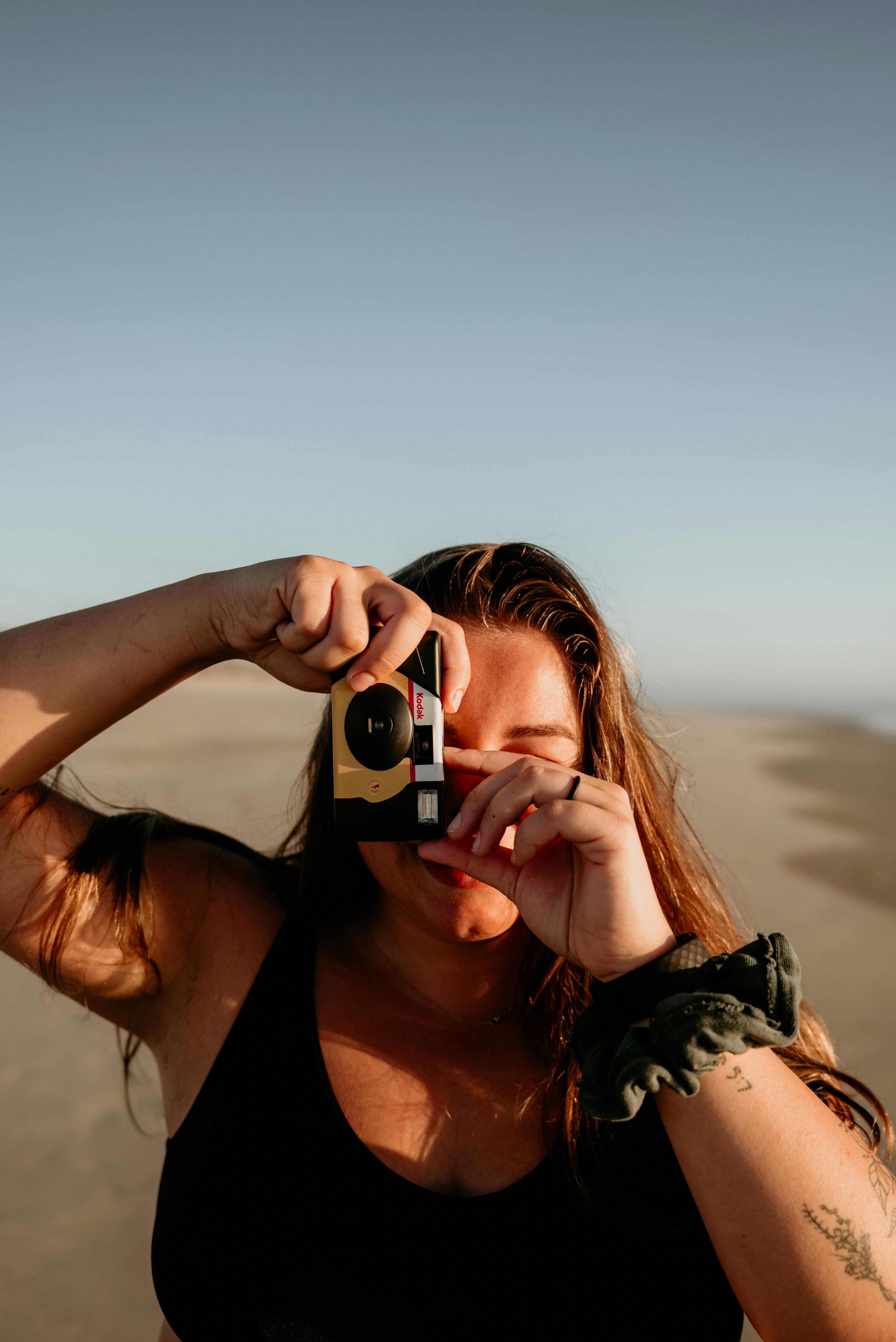 Woman on a Beach Taking Photographs with her Camera · Free Stock Photo