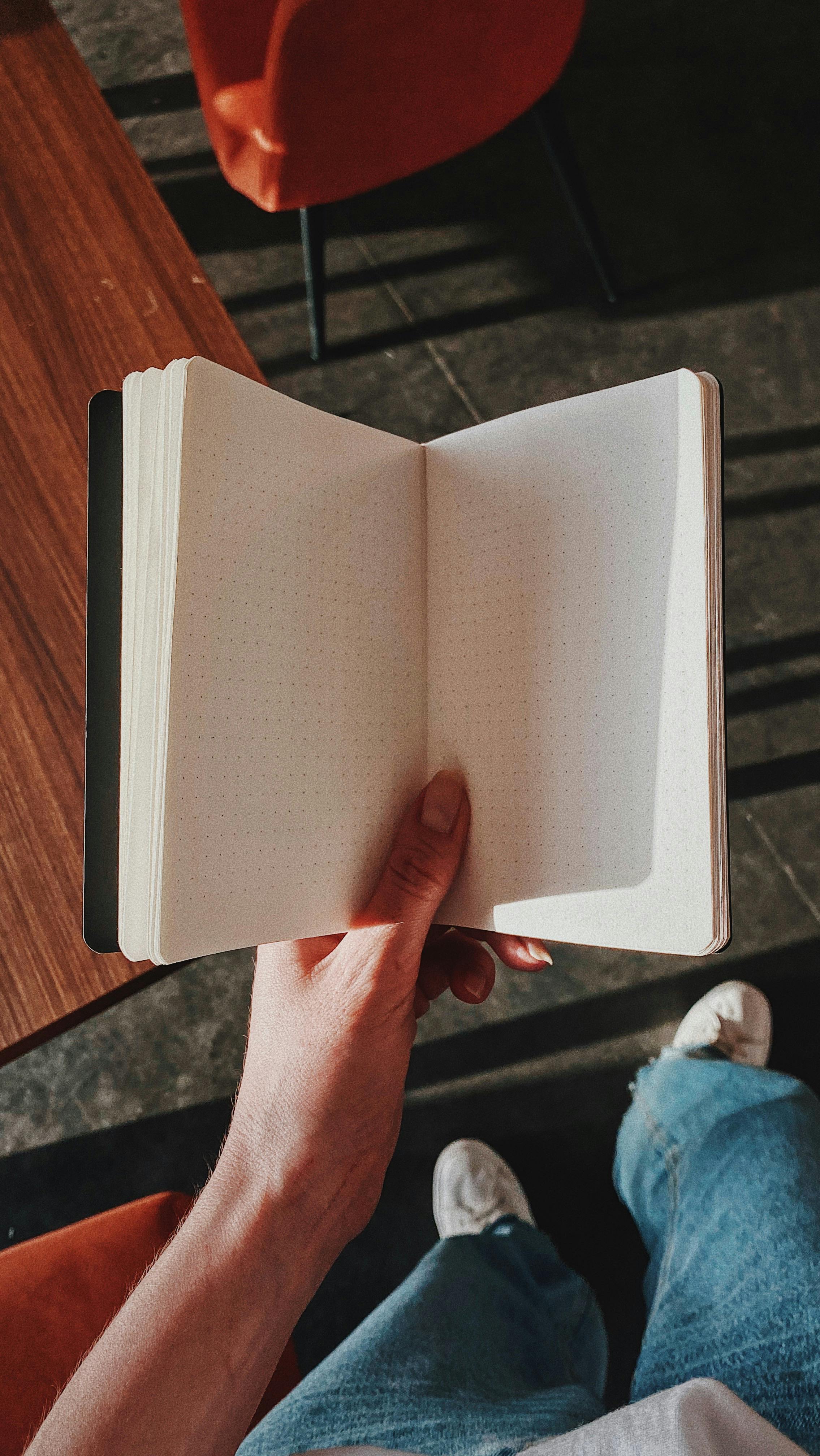 Photo of a Person's Hand Holding a Notebook · Free Stock Photo