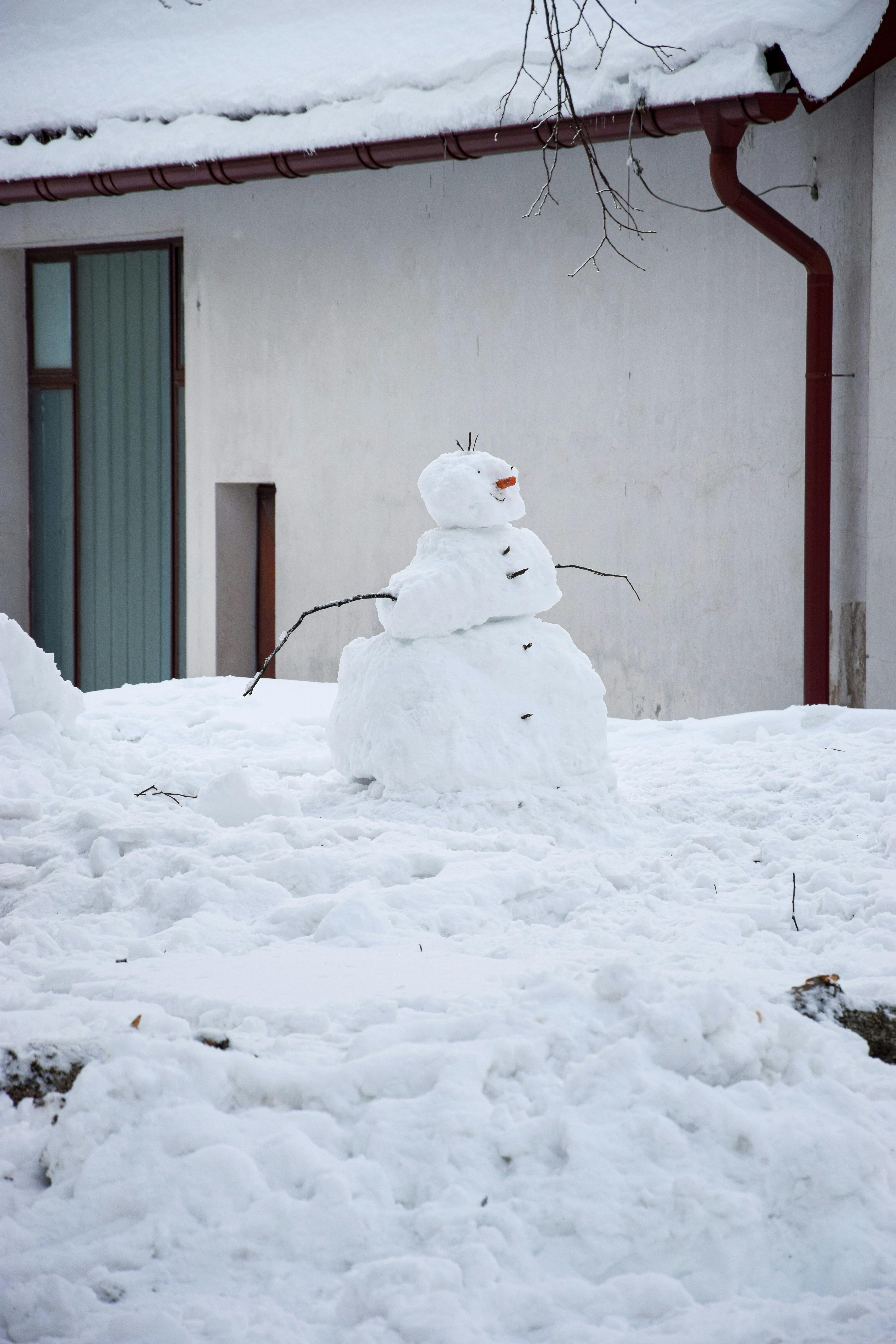 Snowman in Front of a House · Free Stock Photo
