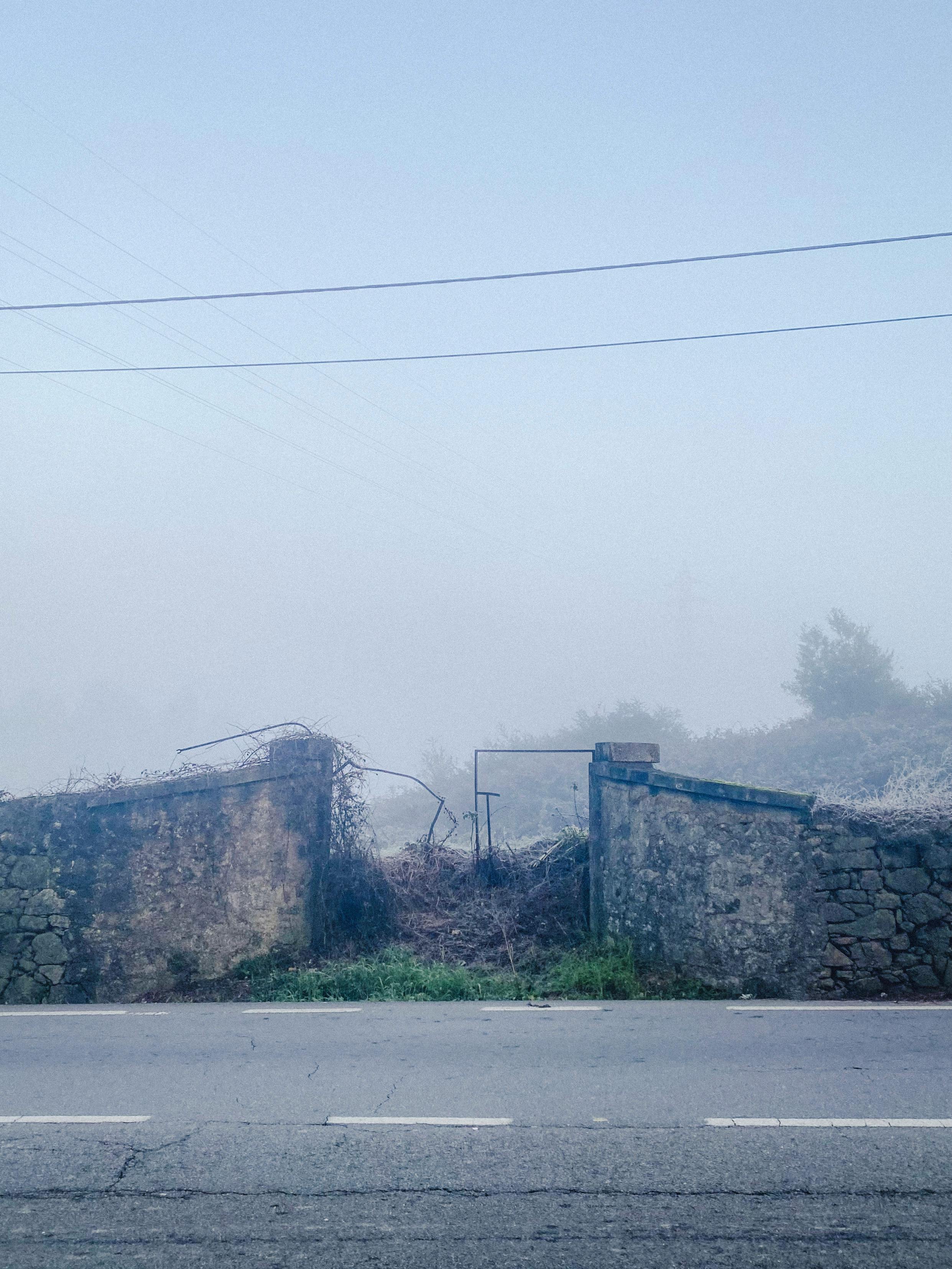 Vista De Un Muro Roto Cerca De Una Carretera Asfaltada Bajo Un Cielo ...
