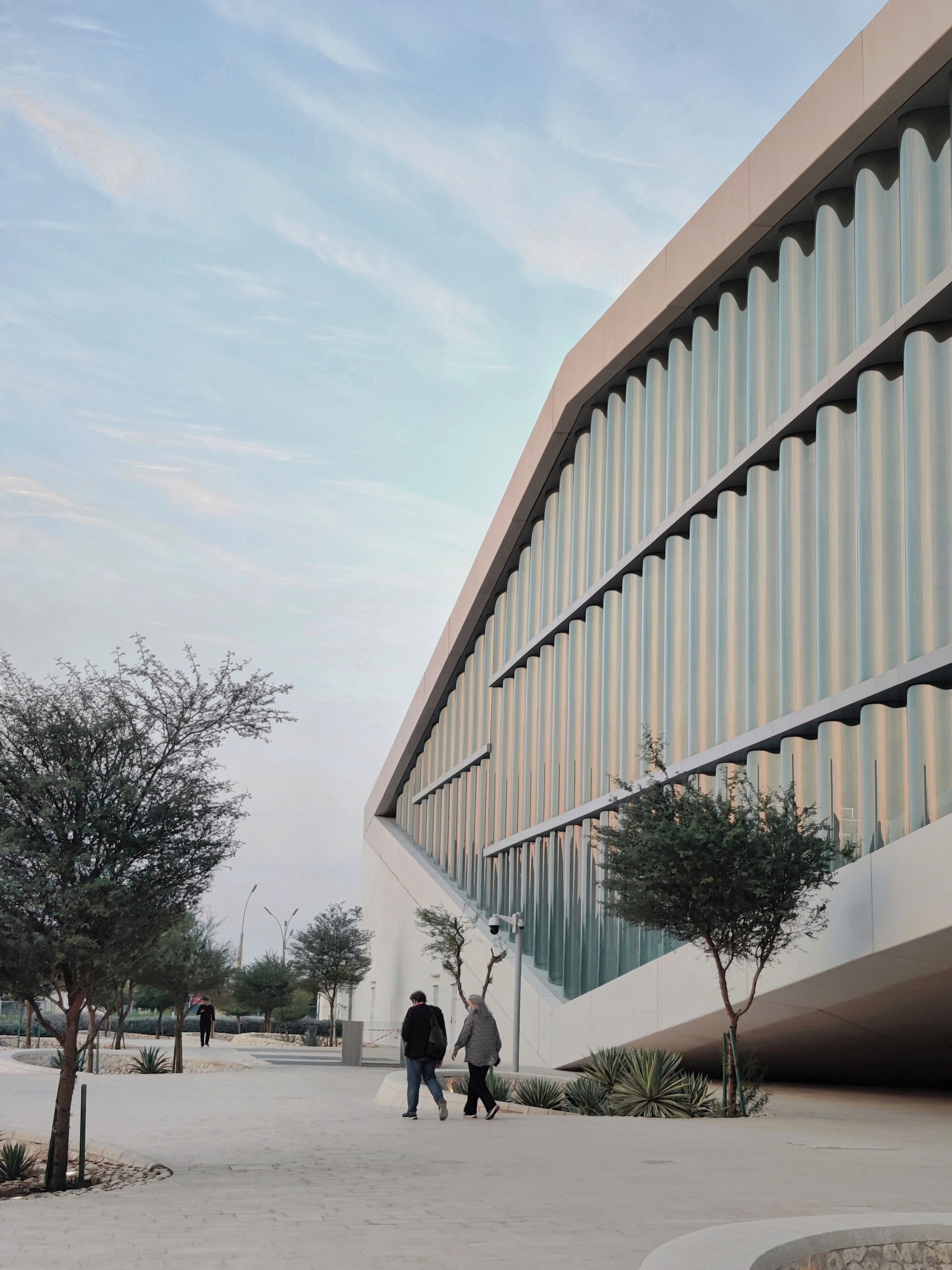 A Couple Walking Beside Concrete Building · Free Stock Photo