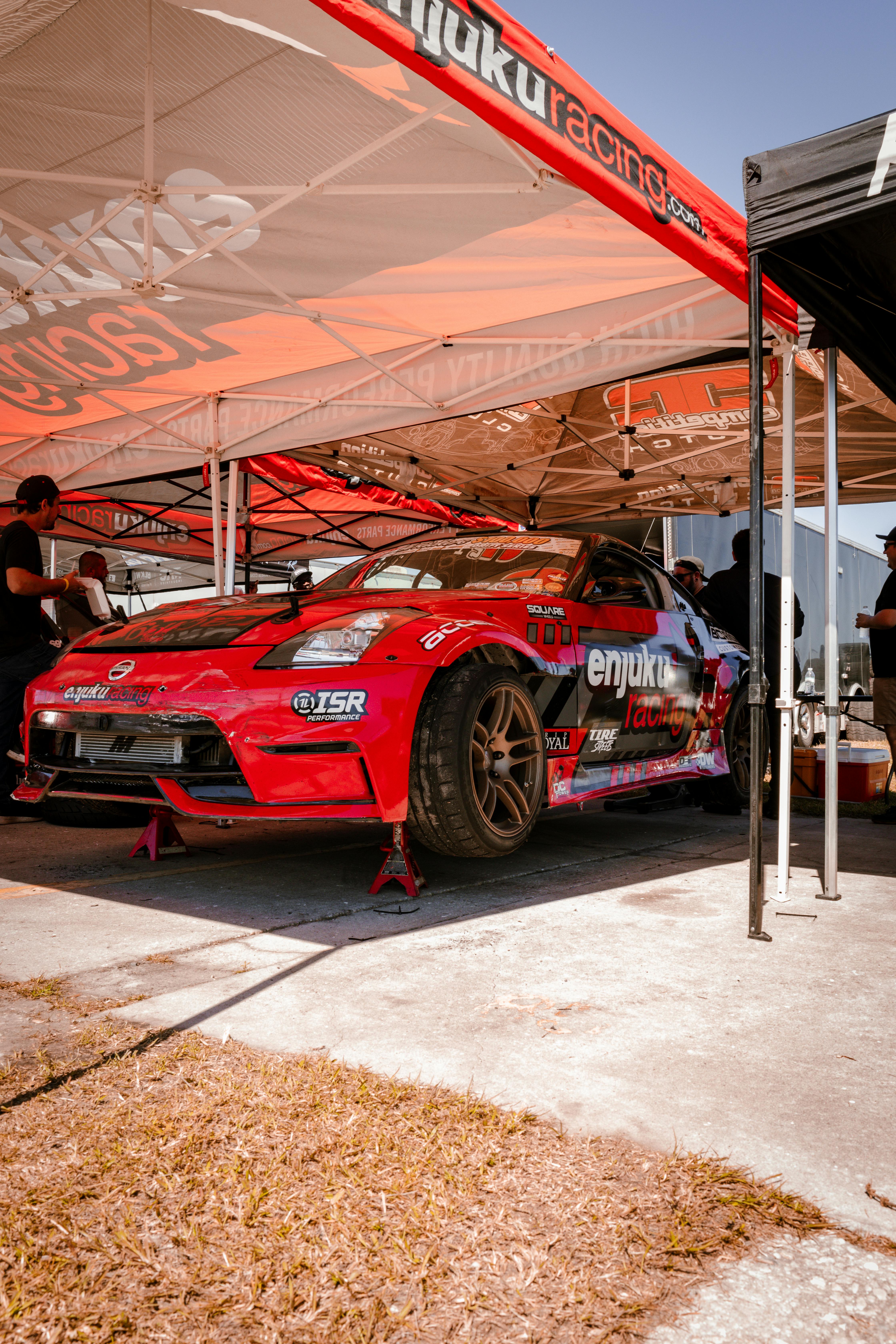 Nissan 350Z Race Car Under a Tents Raised on Jack Stands · Free Stock Photo