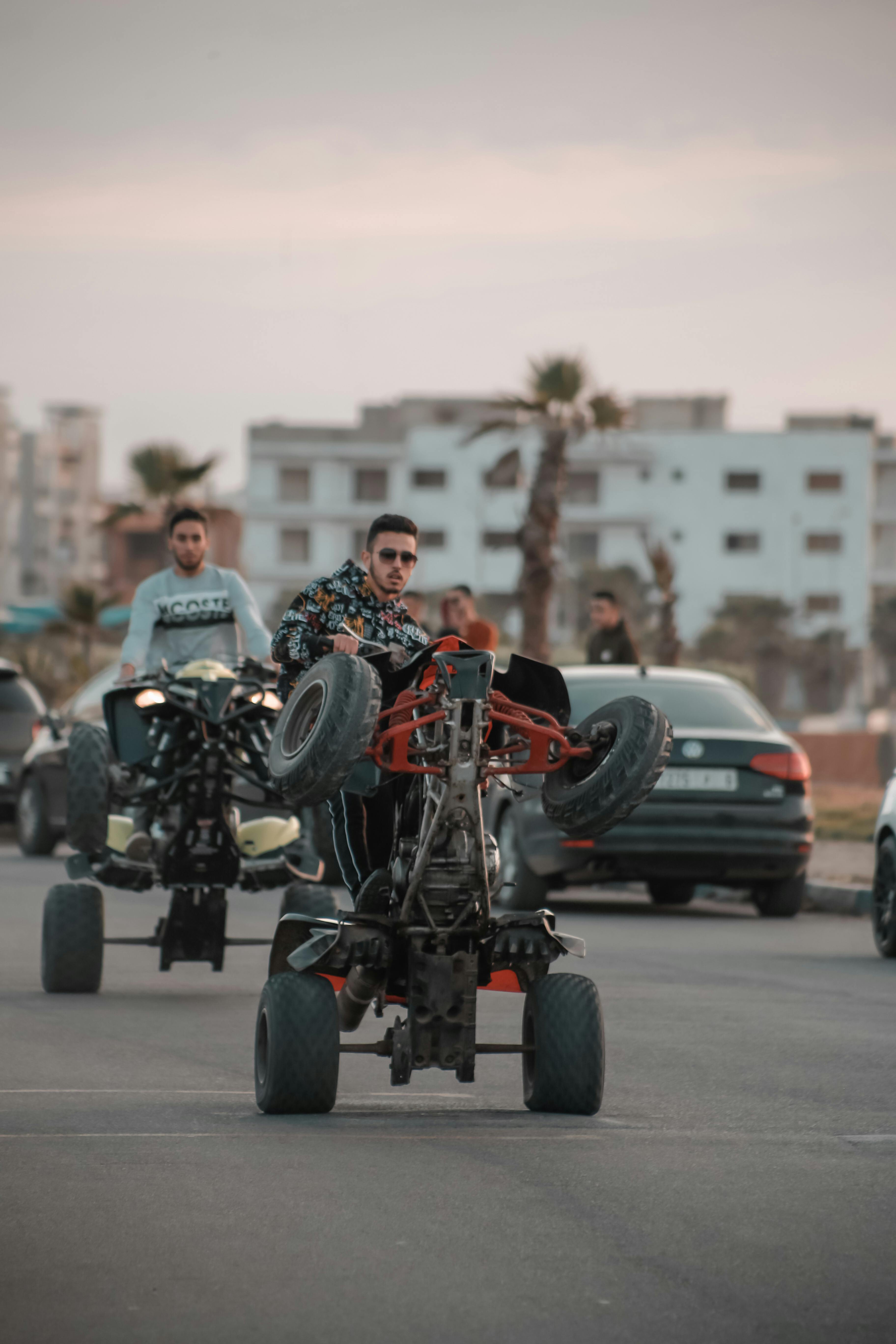 Men Riding Go-karts on Asphalt at Dusk · Free Stock Photo