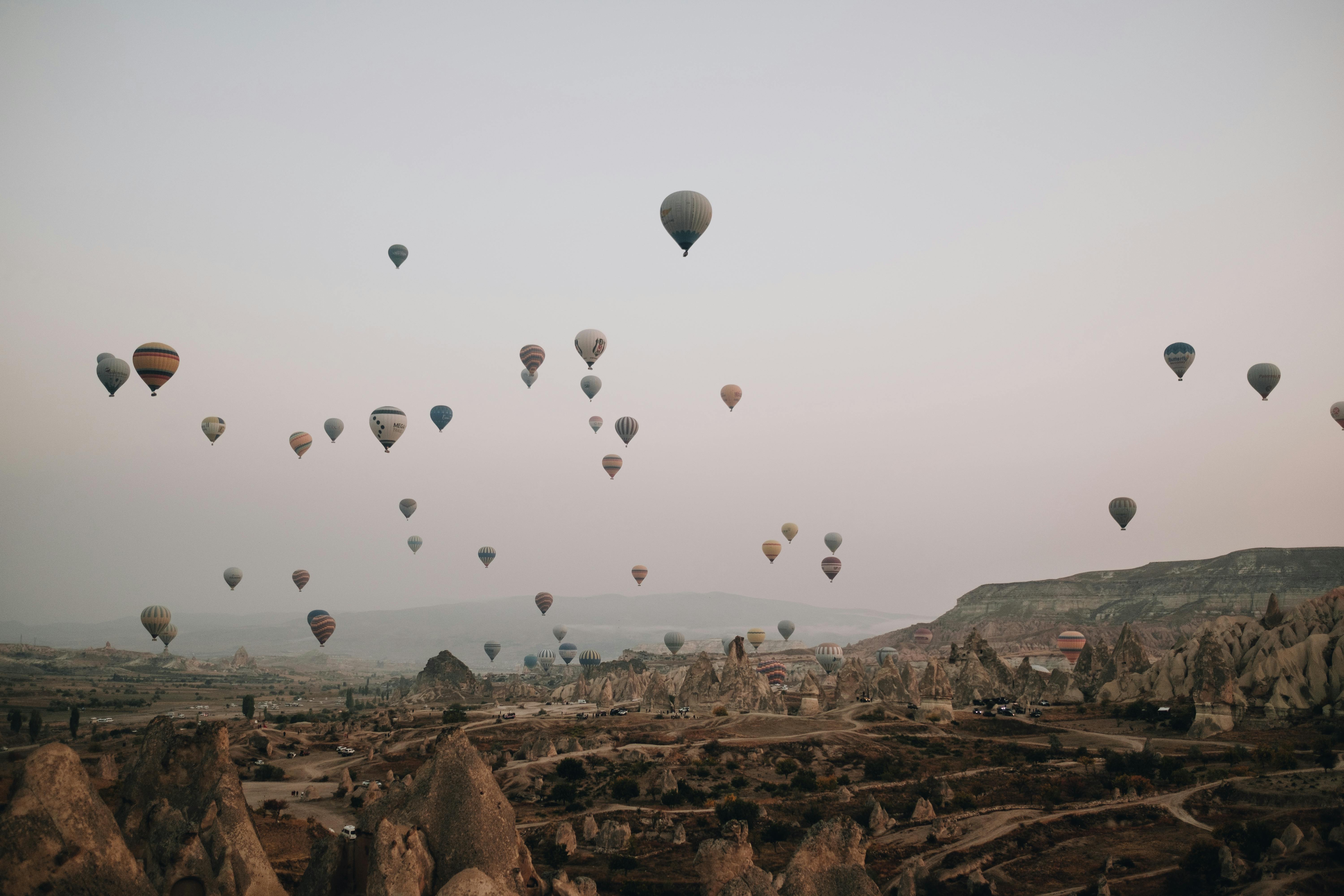 Hot Air Balloons Floating Over Rock Formations · Free Stock Photo