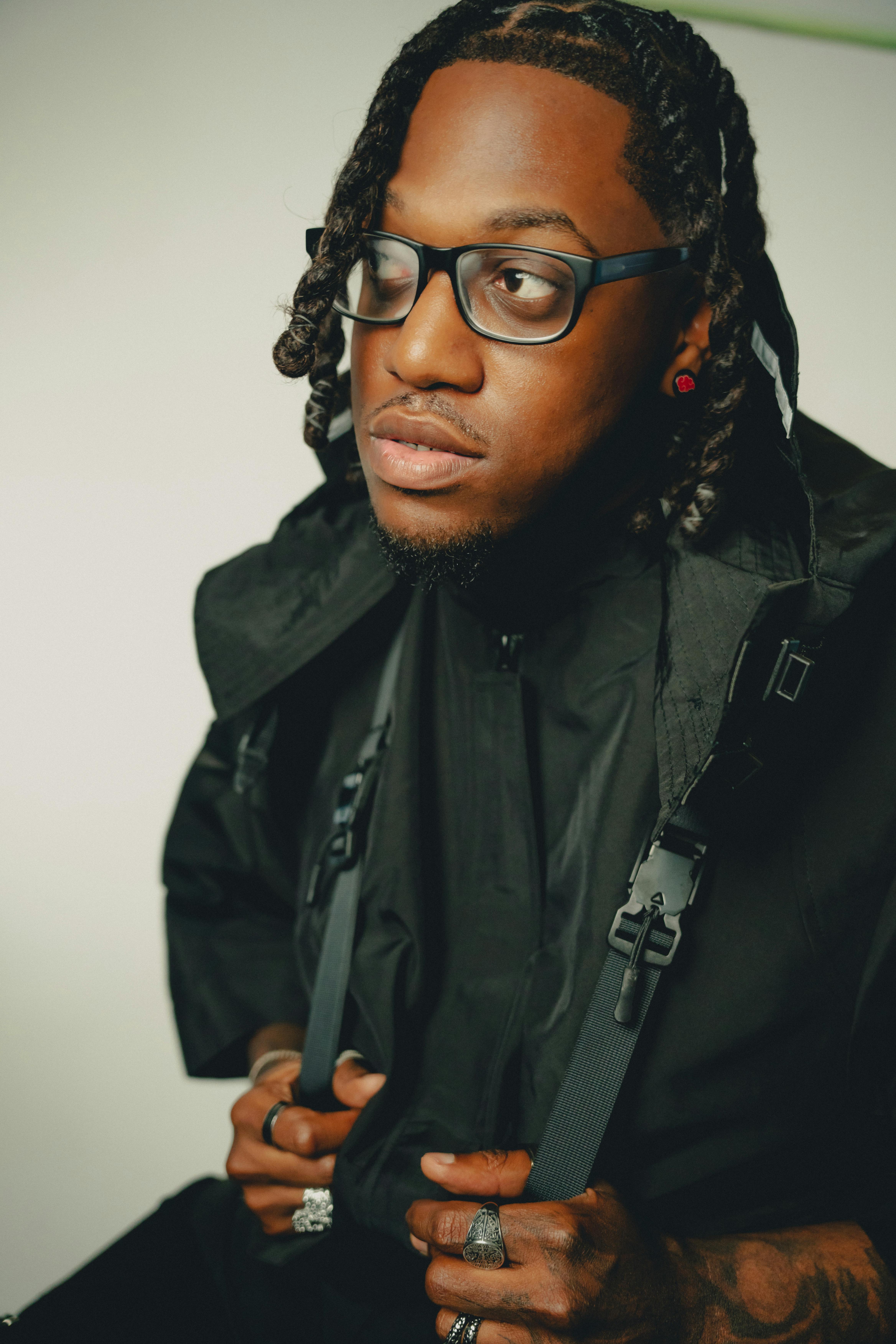 Man with Dreadlocks in Outerwear Posing in Studio · Free Stock Photo
