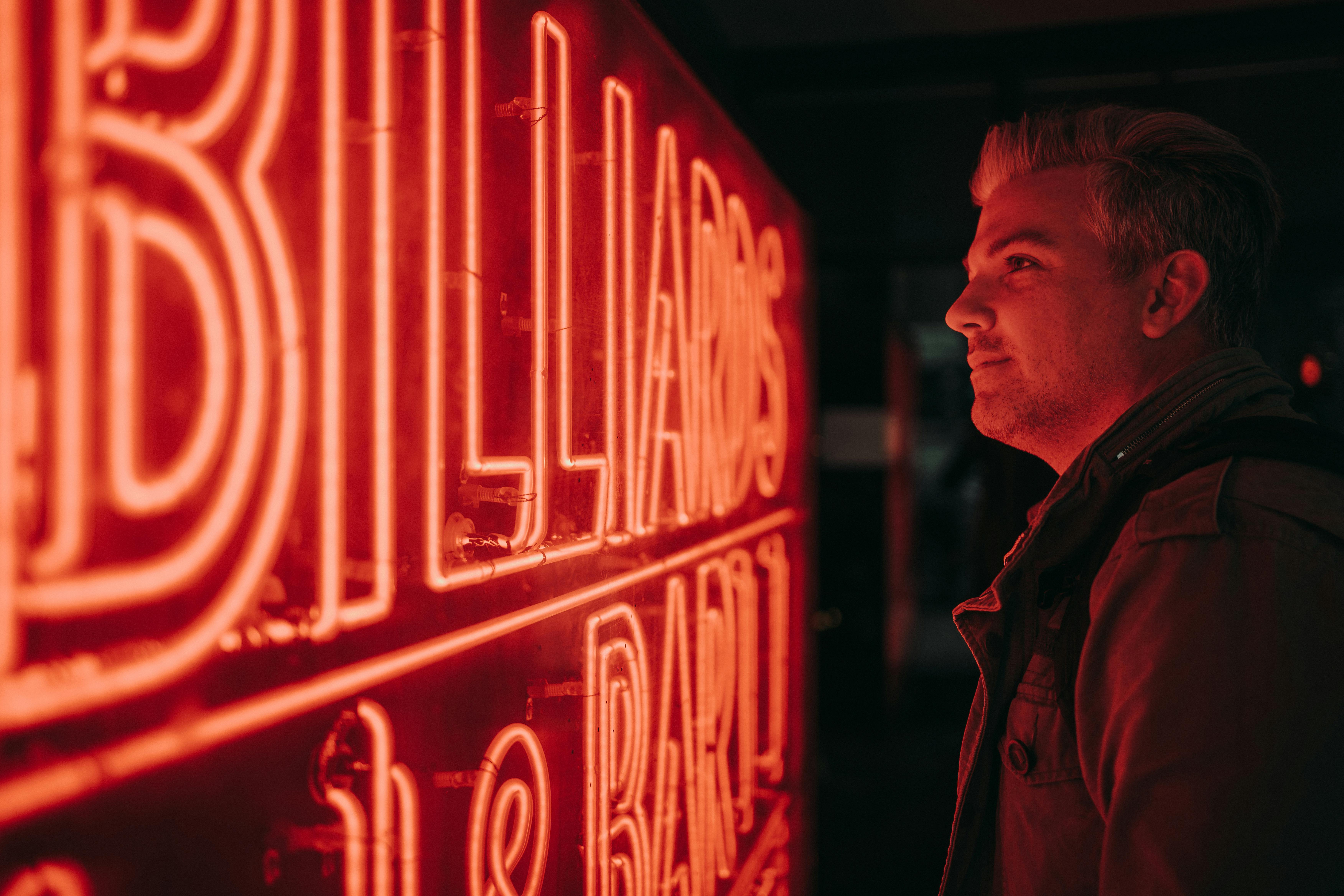 Man Standing in Front of Neon Sign · Free Stock Photo