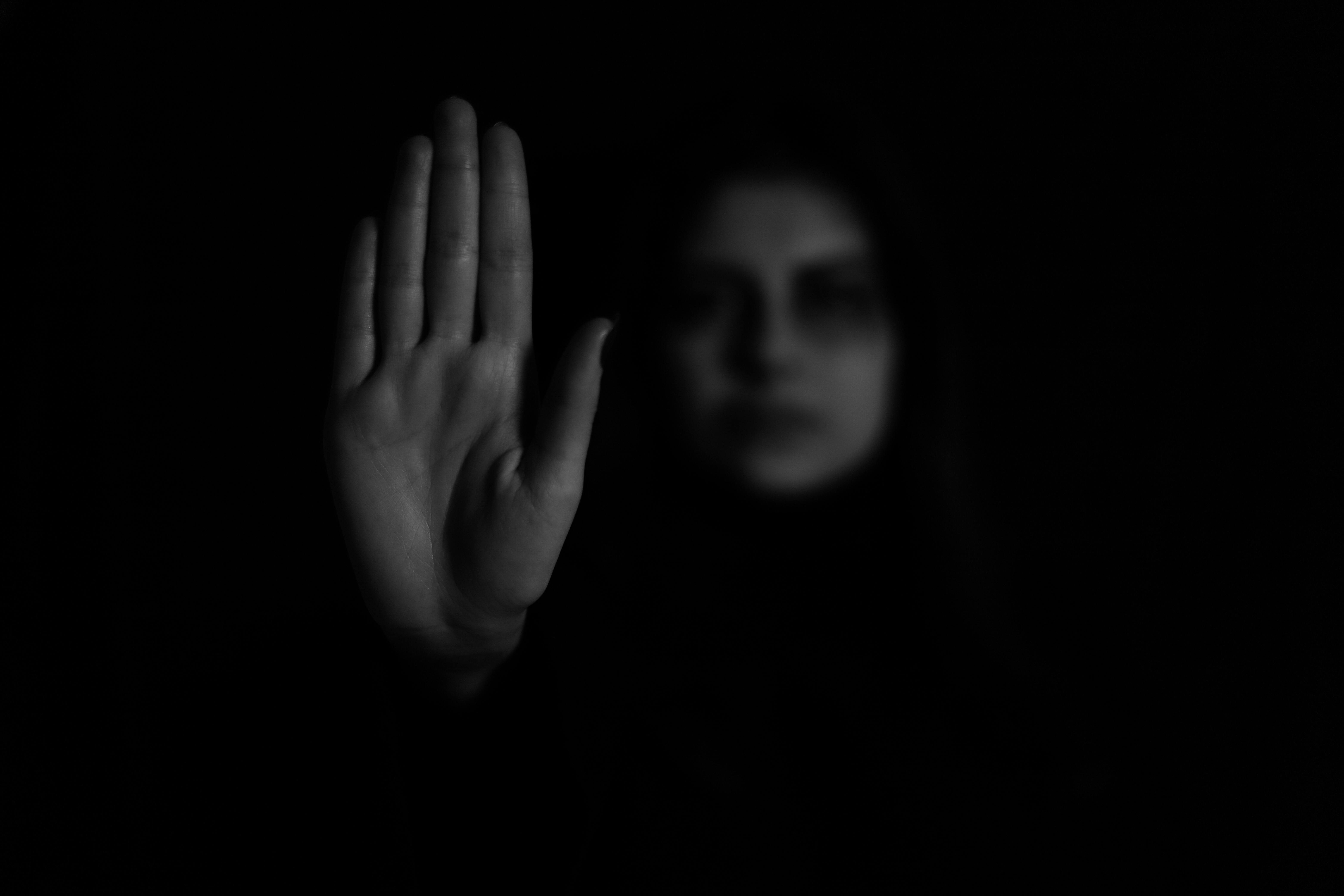 Grayscale Phot of a Person Signaling Stop · Free Stock Photo