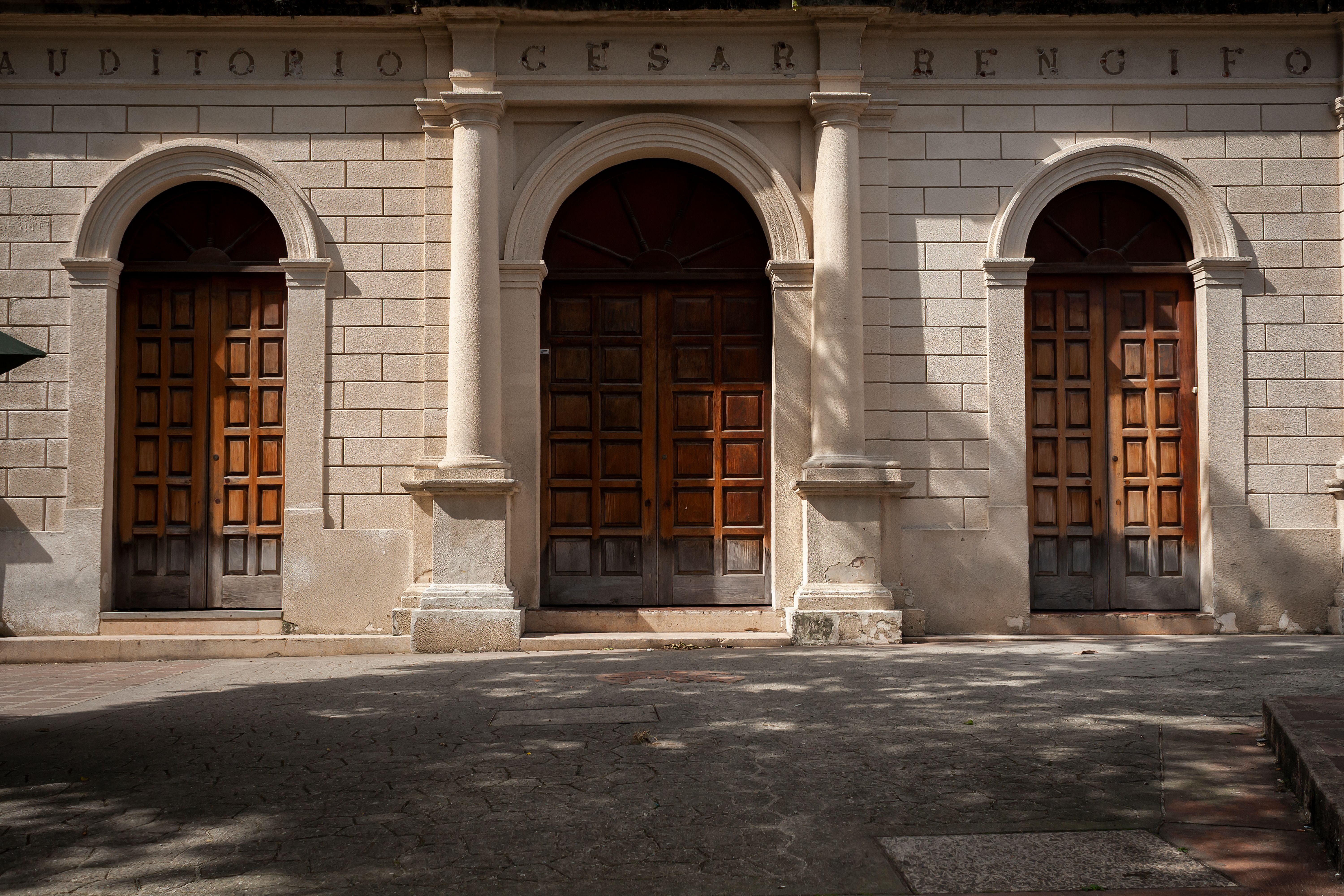 A building with two large wooden doors and a stone wall · Free Stock Photo