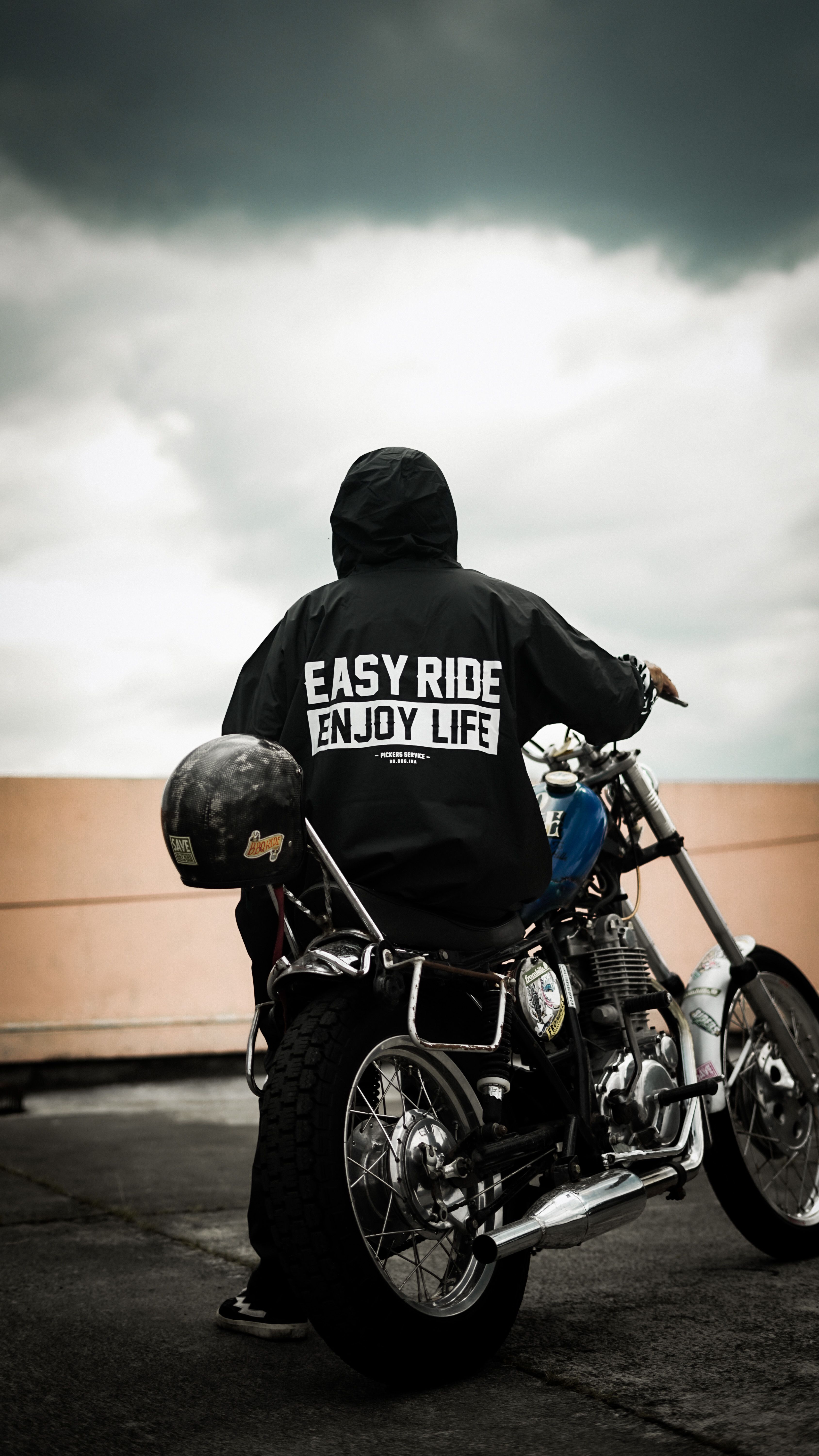 Photo of a Biker Leaning on a Motorcycle Against a Stormy Sky · Free ...