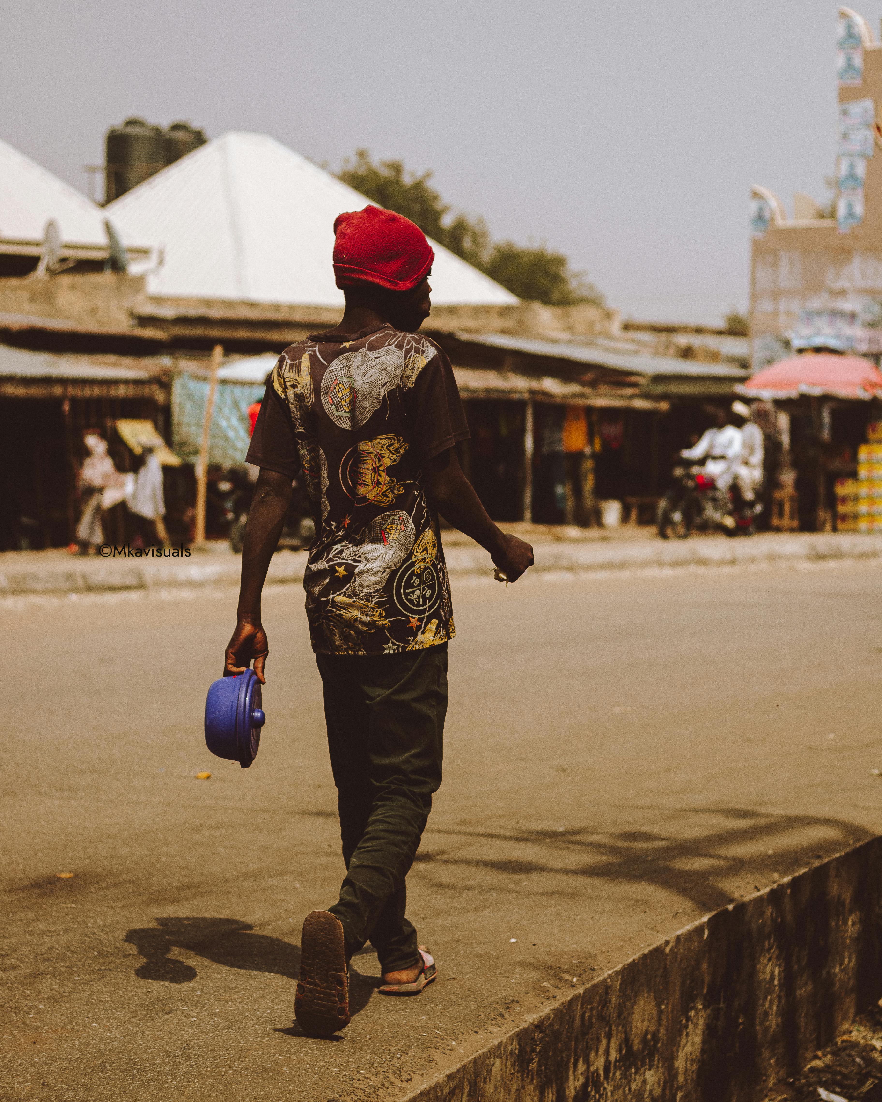 Man Walking on Street near Bazaar · Free Stock Photo