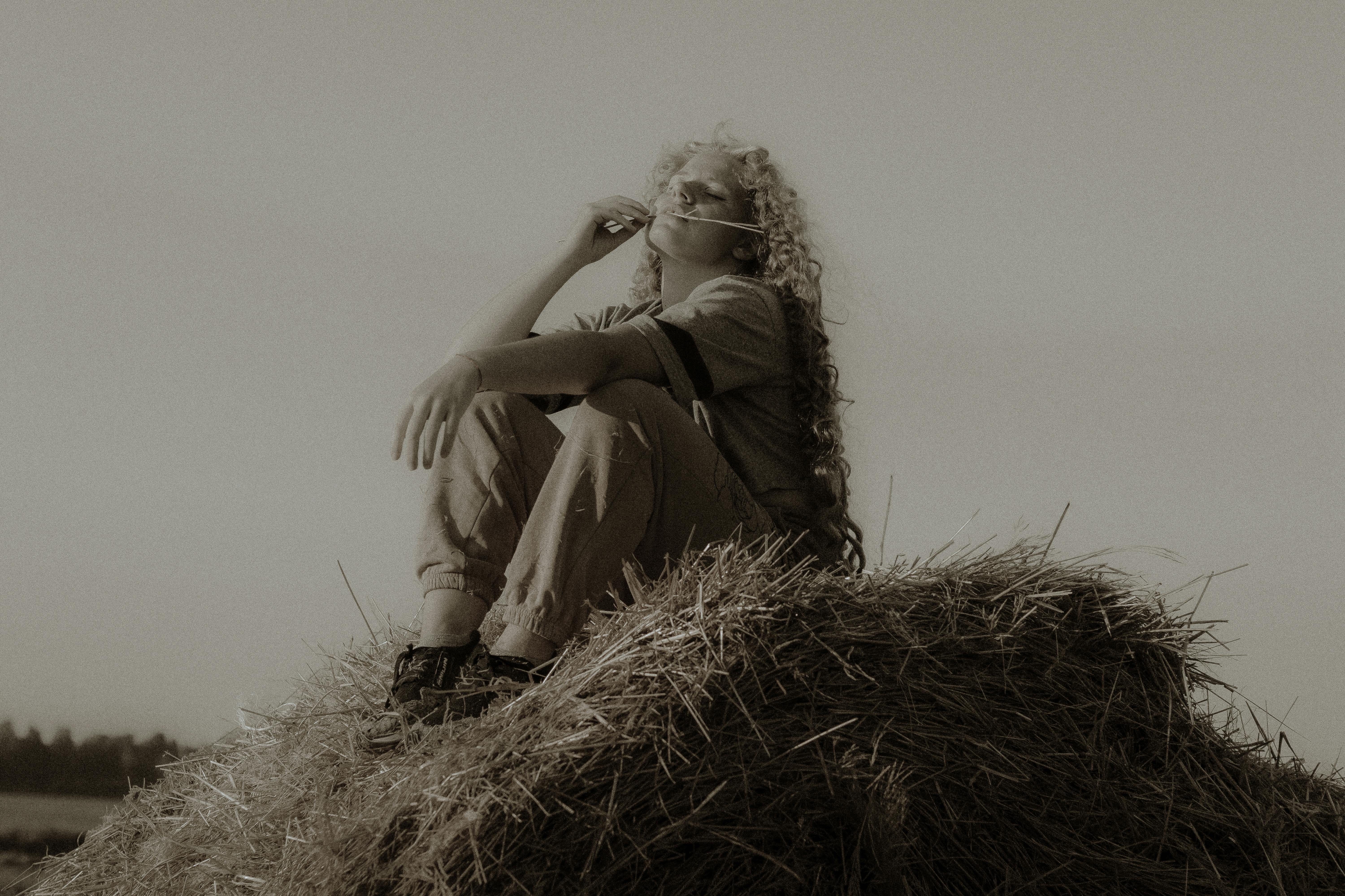 Woman Sitting on Haystack · Free Stock Photo