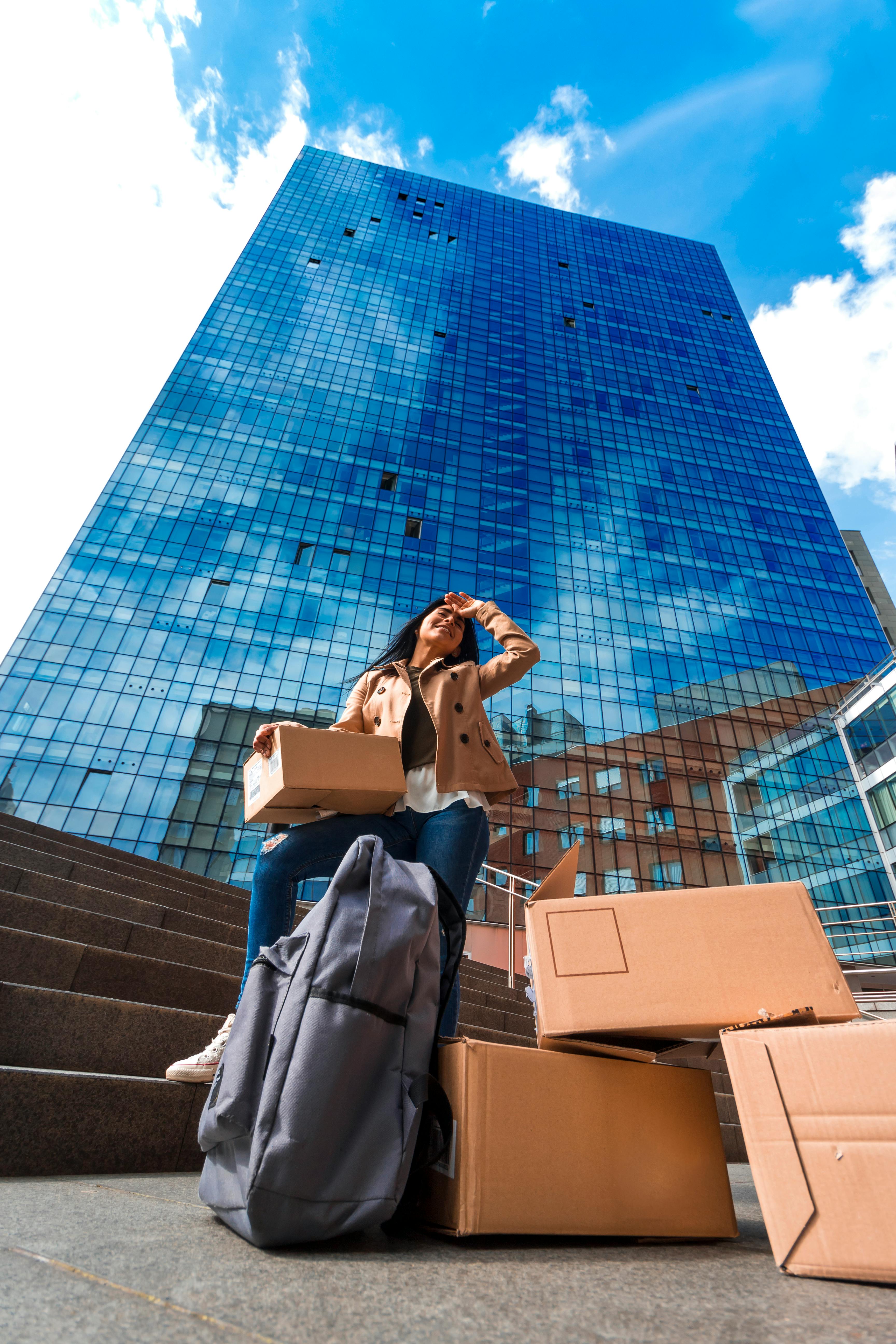 Woman with Boxes against Skyscraper · Free Stock Photo