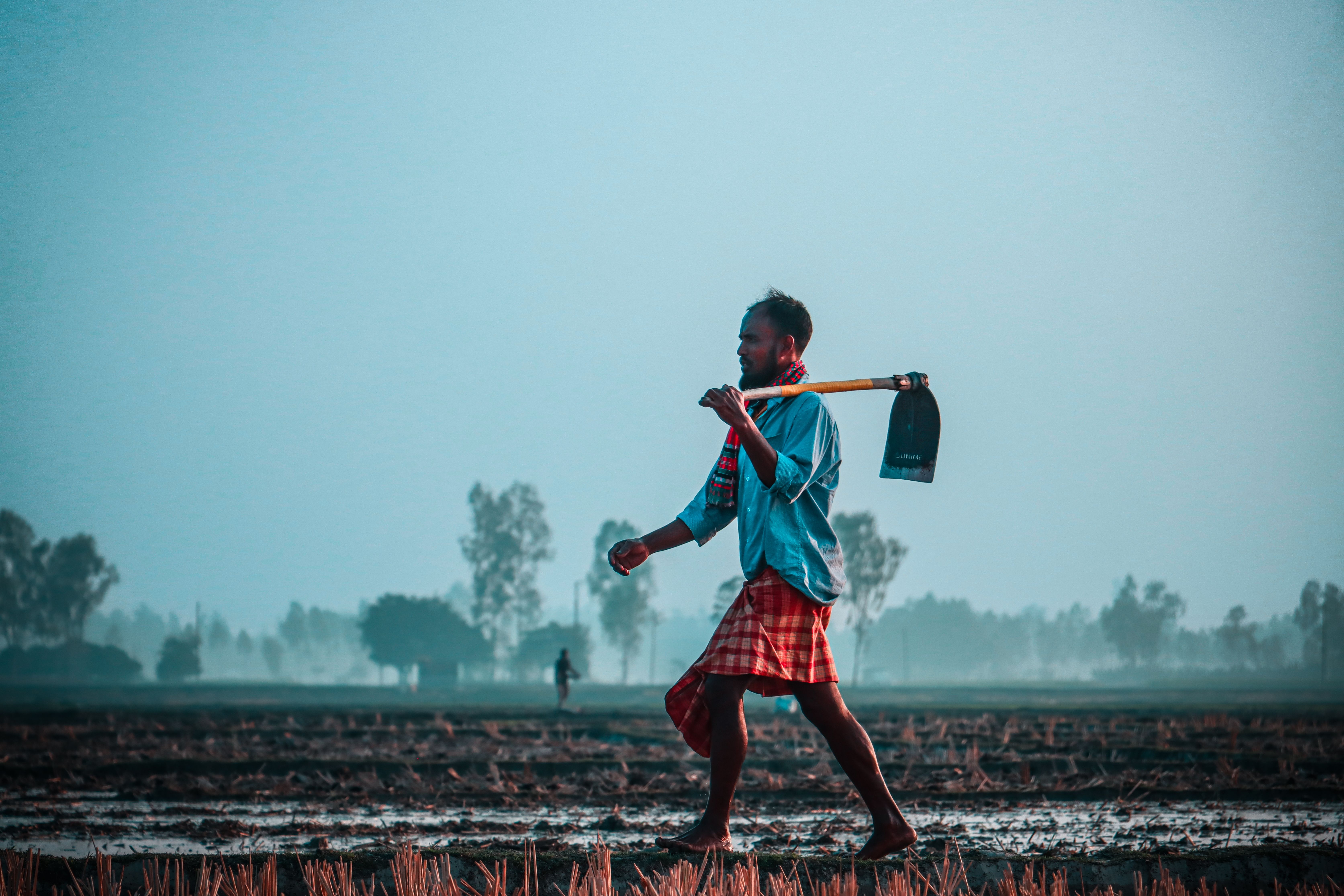 Man Walking with Hoe on Shoulder · Free Stock Photo