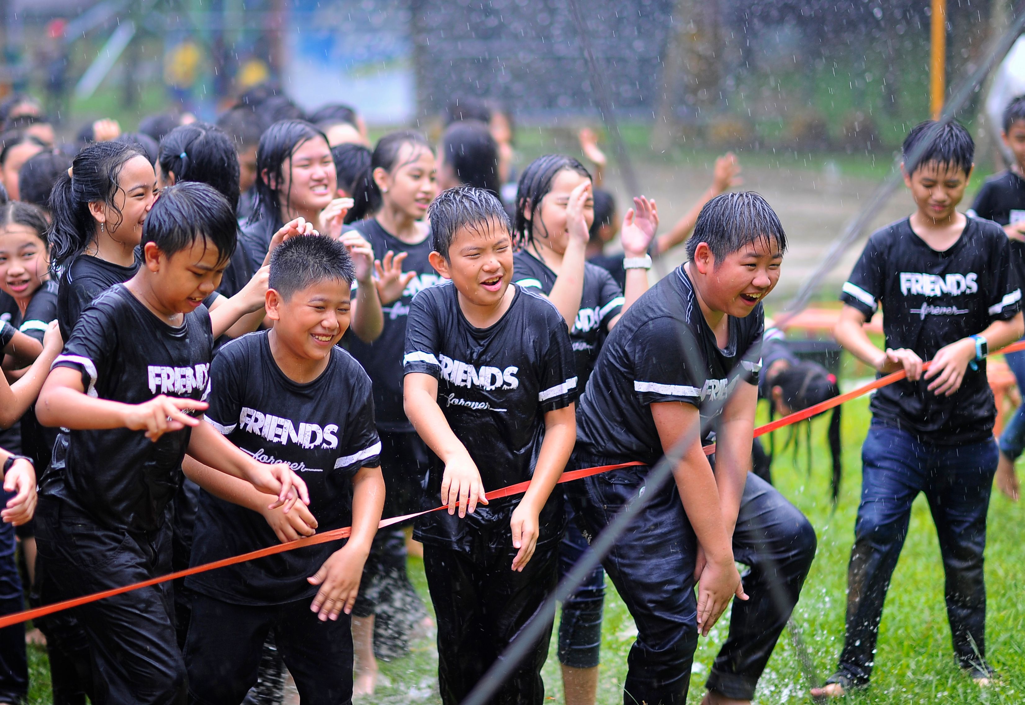 A Group of Schoolkids Laughing while Standing Outdoors in Rain · Free ...