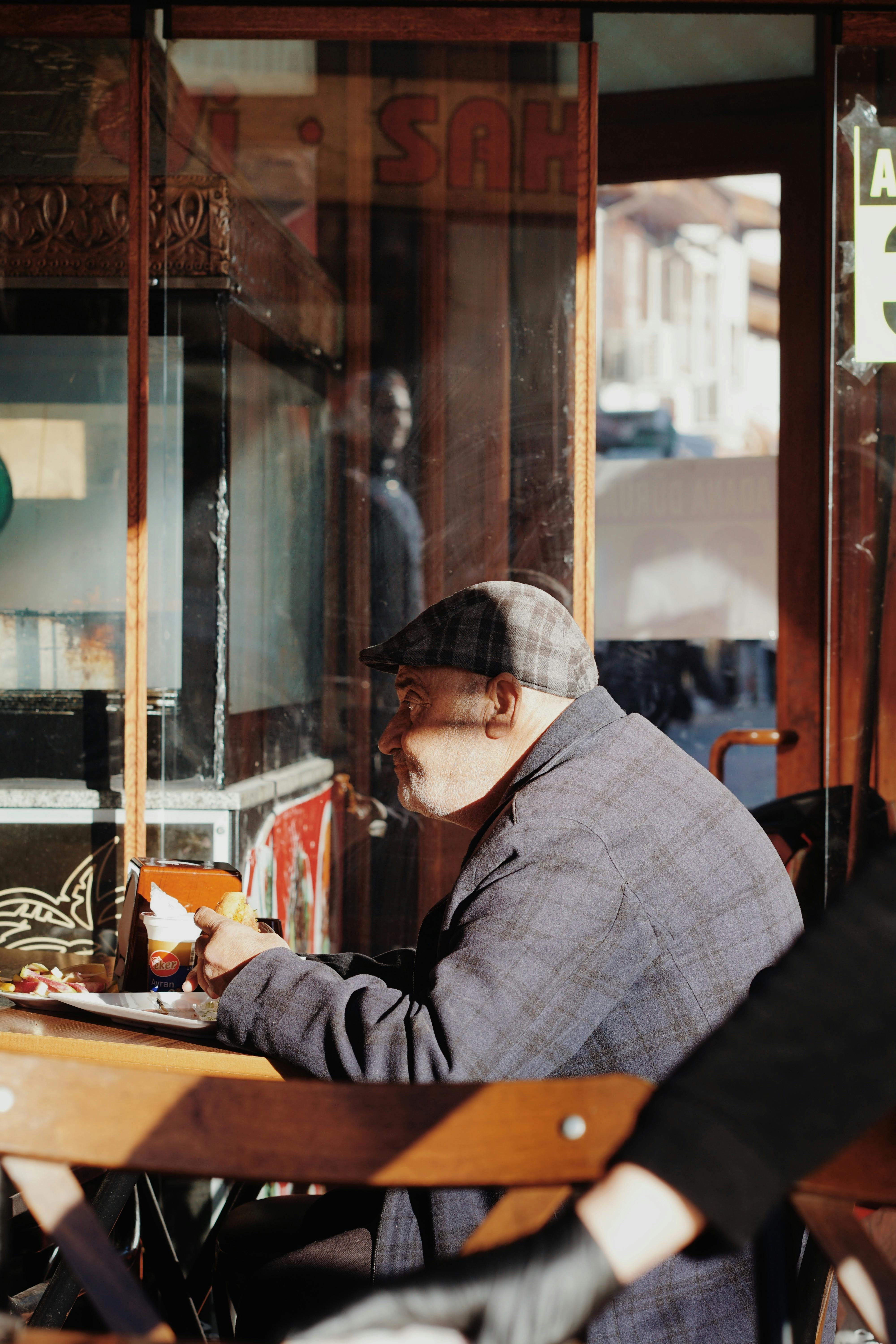 Hunched Man Eating in a Diner · Free Stock Photo