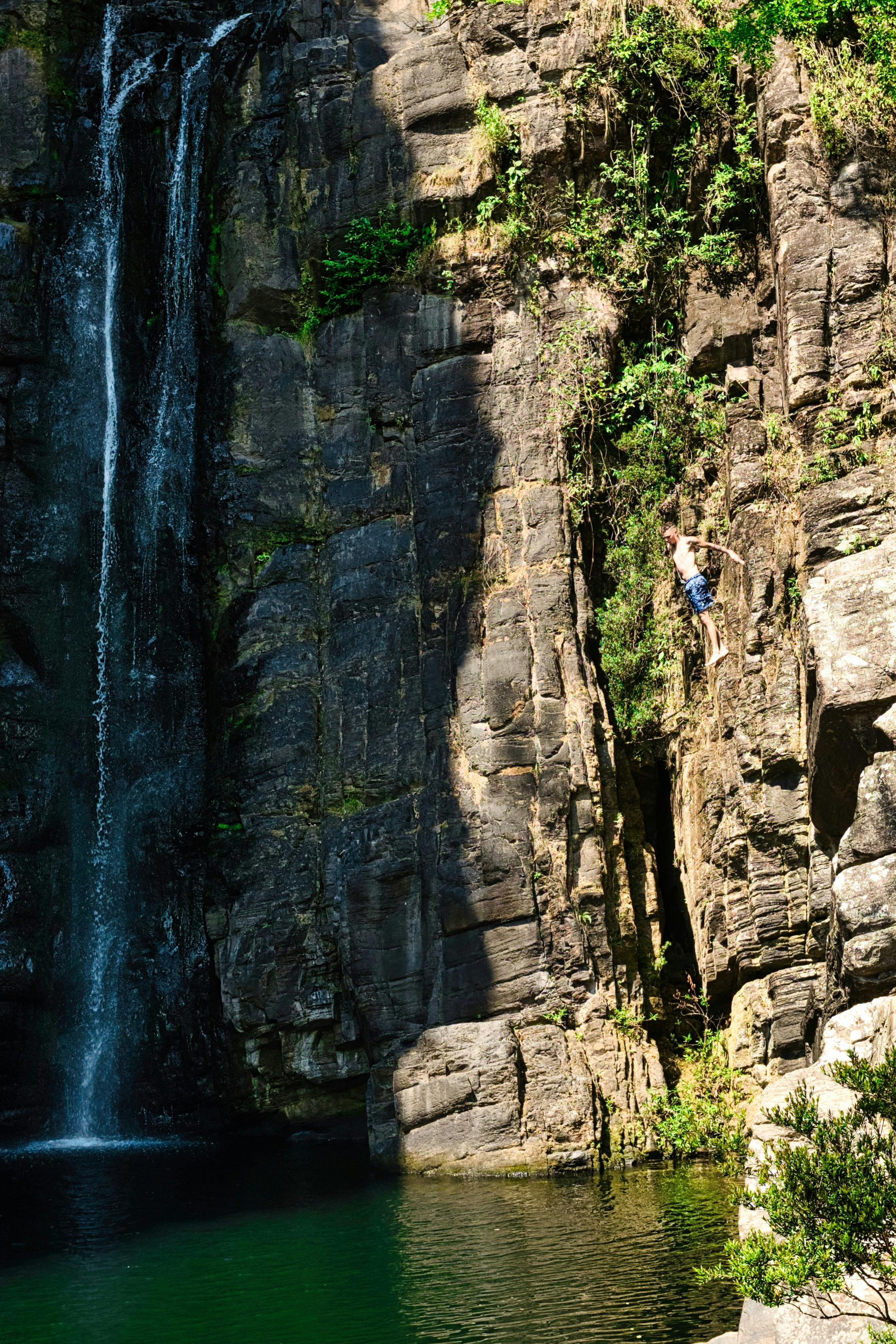 Man on Rocks near Waterfall · Free Stock Photo