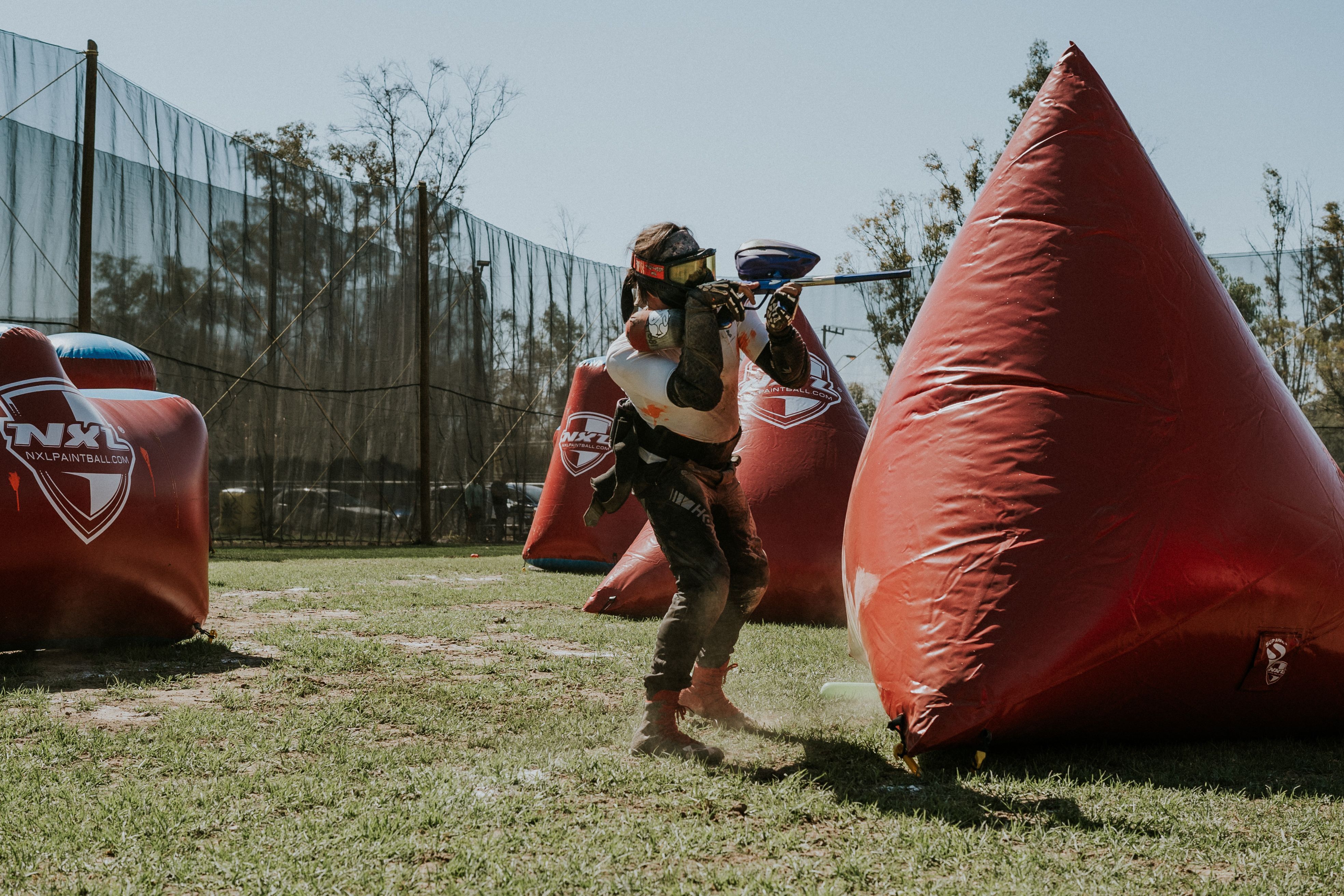 Man Readjusting His Position During a Game of Paintball · Free Stock Photo