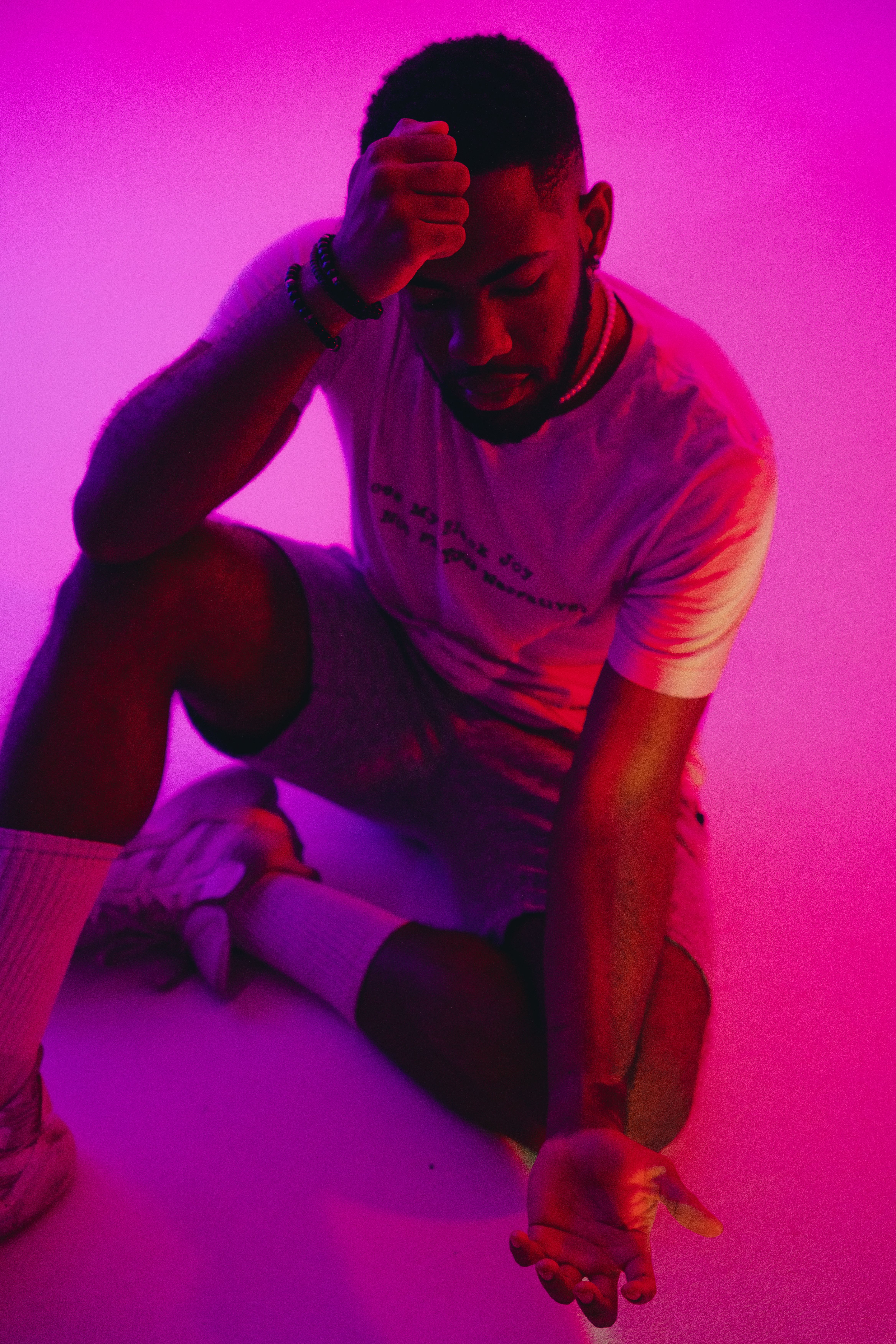 Man Sitting on Pink Background · Free Stock Photo