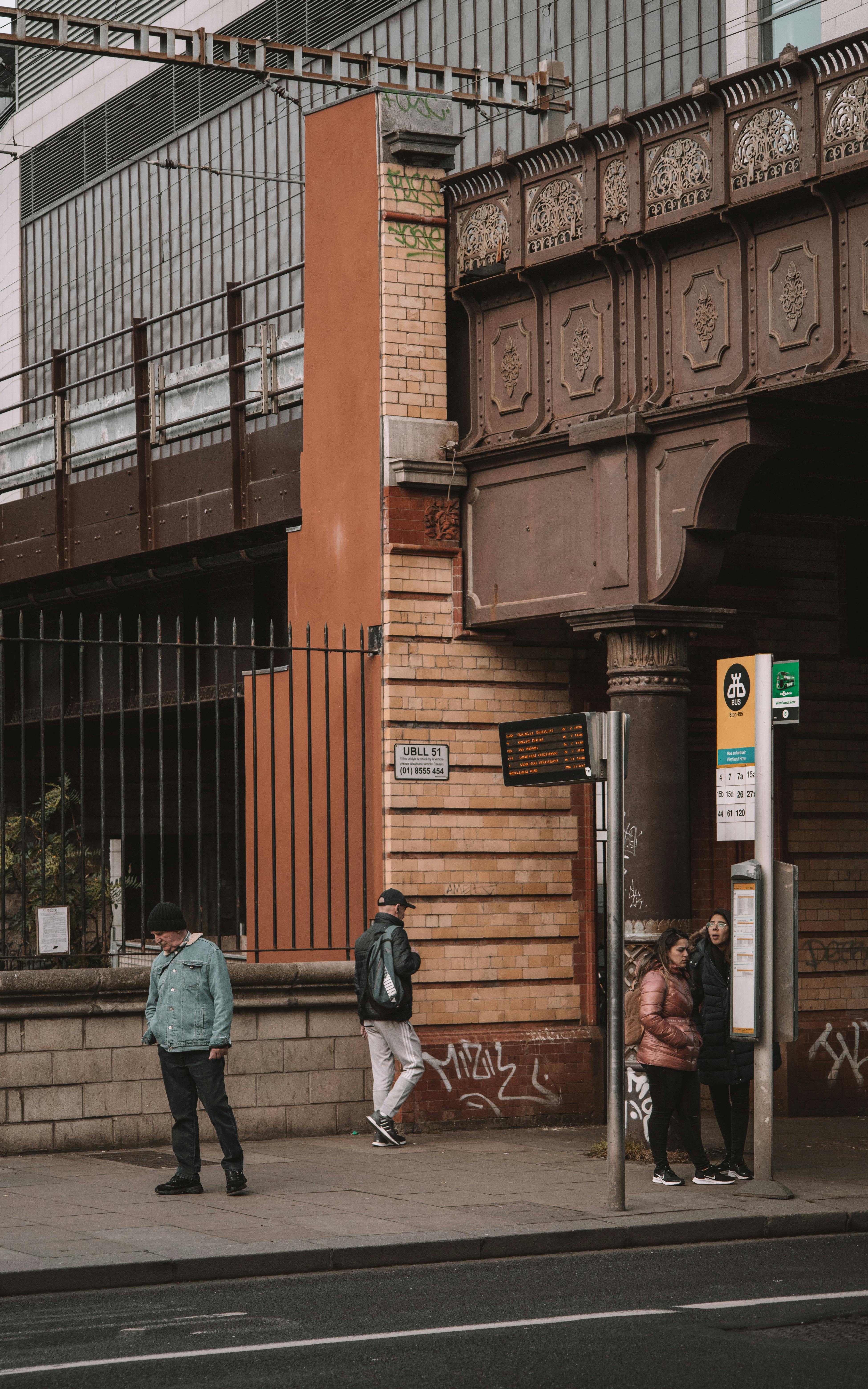 People Sitting on Bench at a Bus Stop · Free Stock Photo