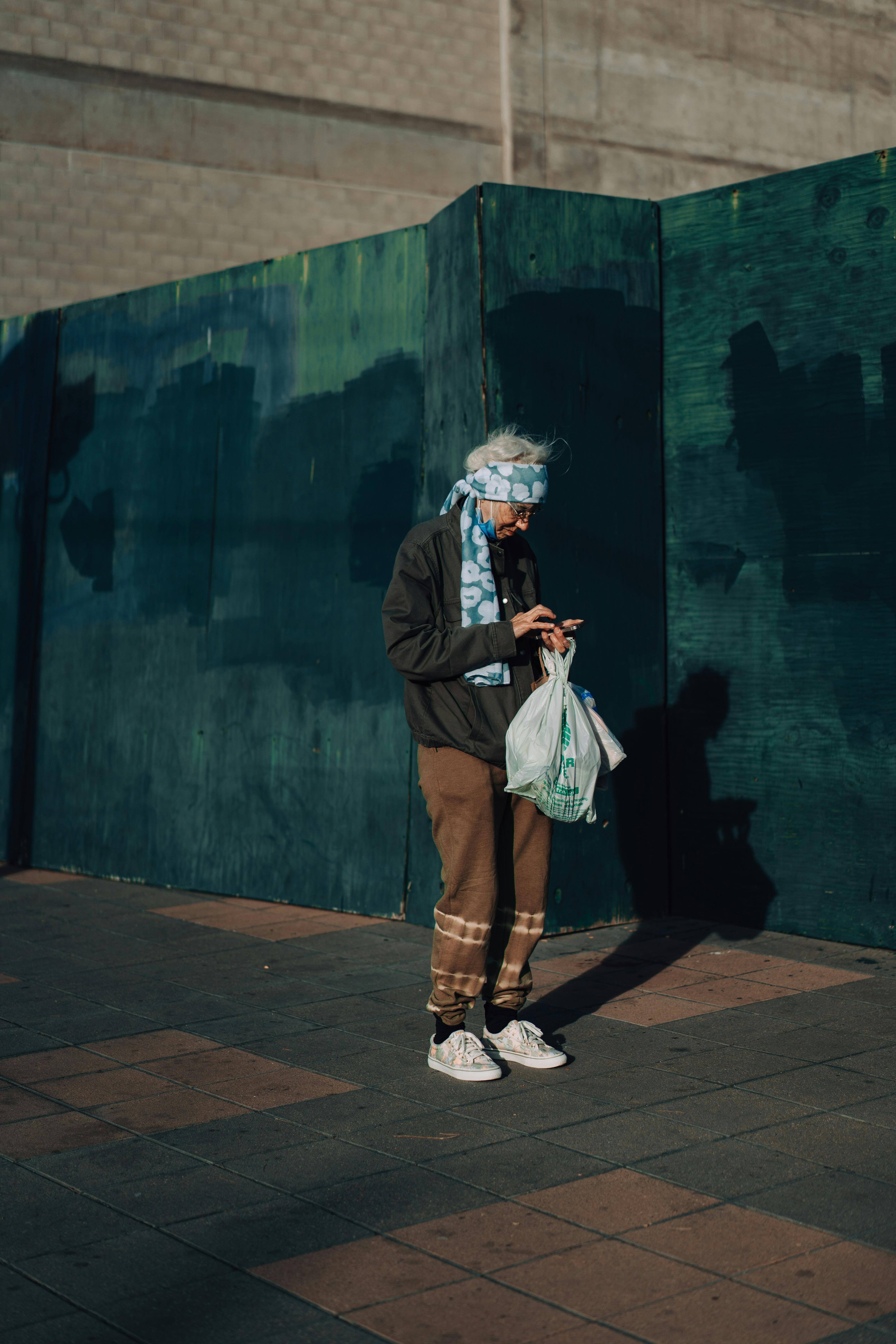 Person in Robes with Hood Standing with Puppets · Free Stock Photo