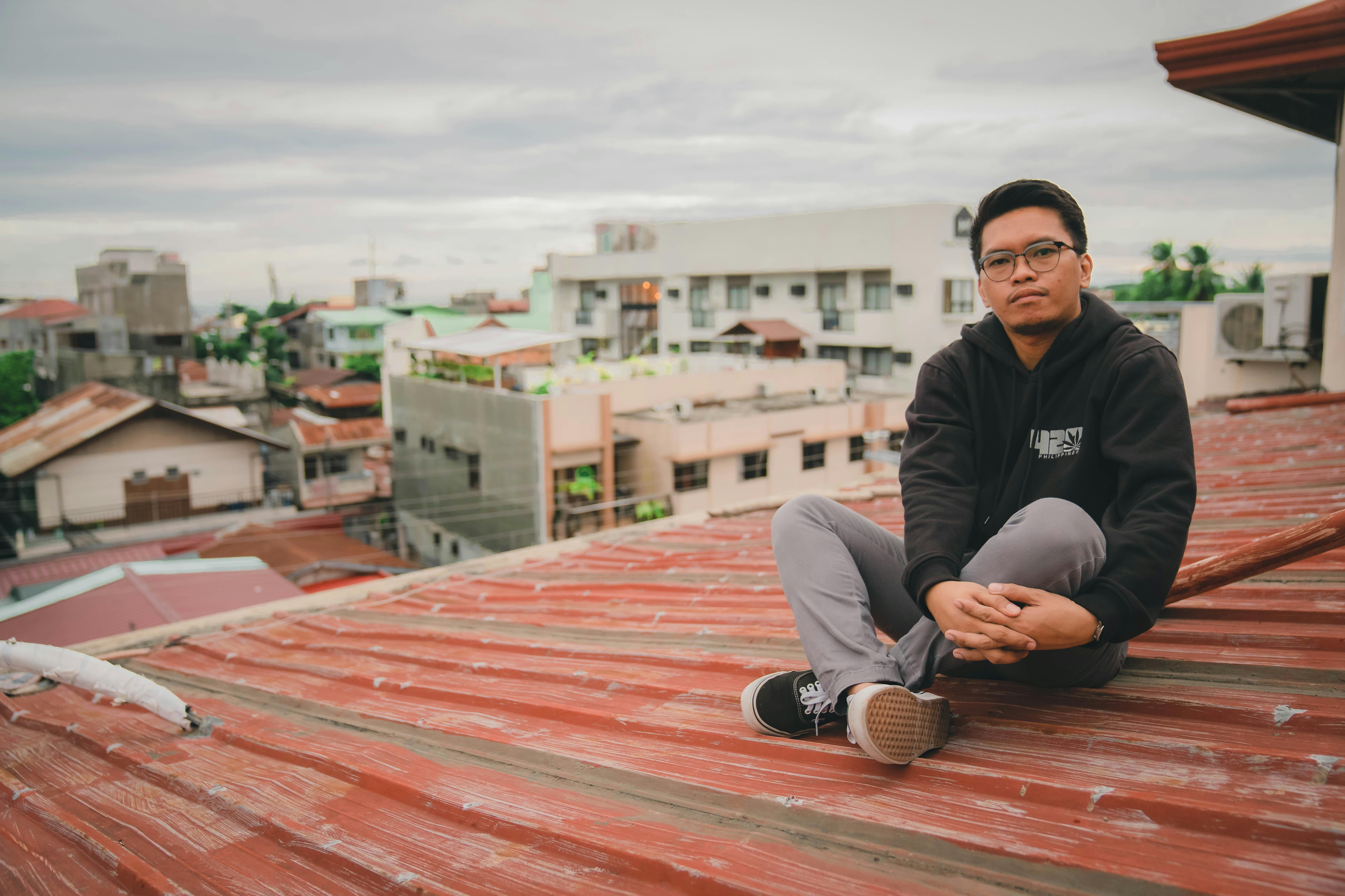 A Man Sitting on a Roof · Free Stock Photo