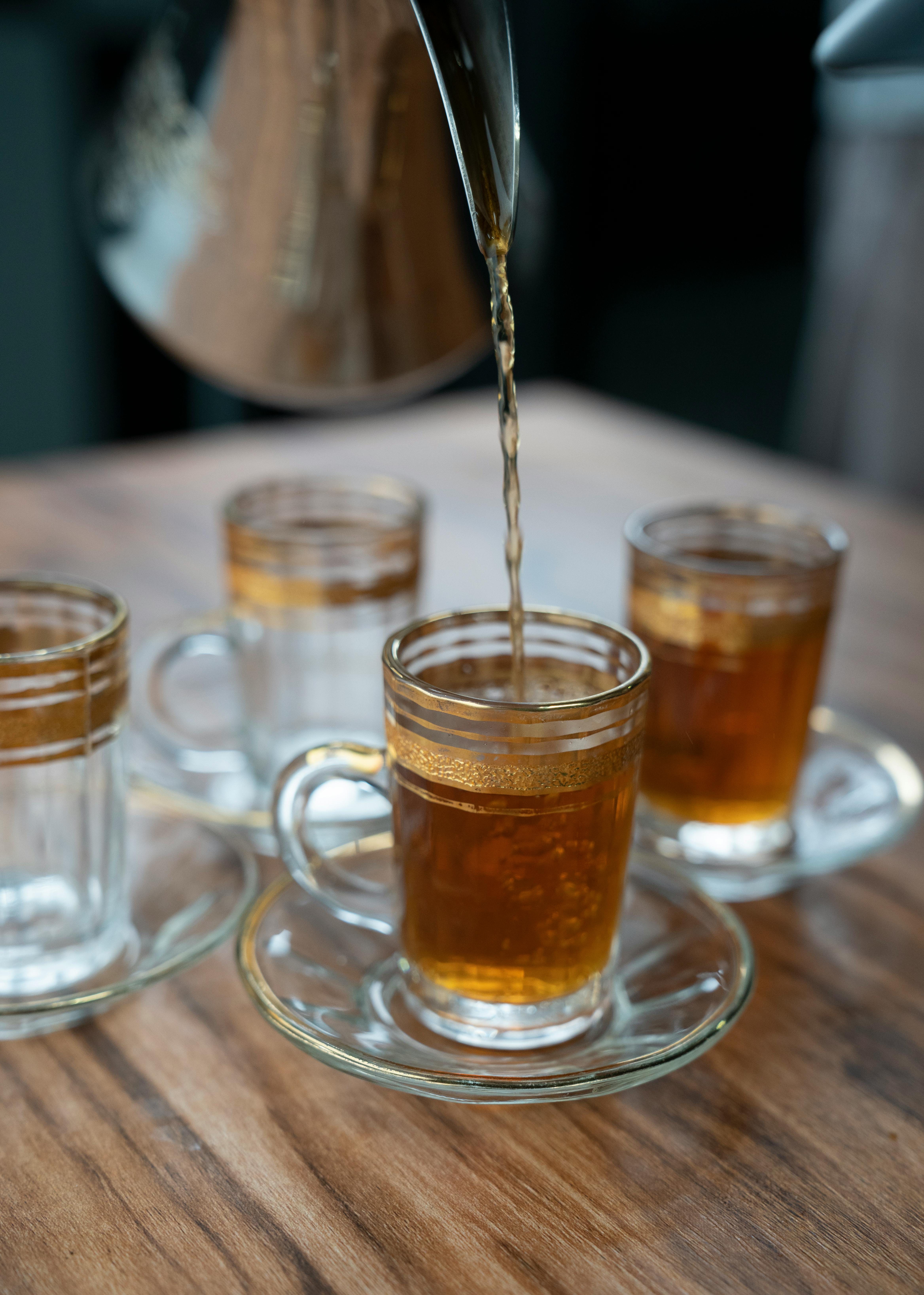 Clear Glass Pitcher Pouring Liquid on Clear Glass Cup · Free Stock Photo